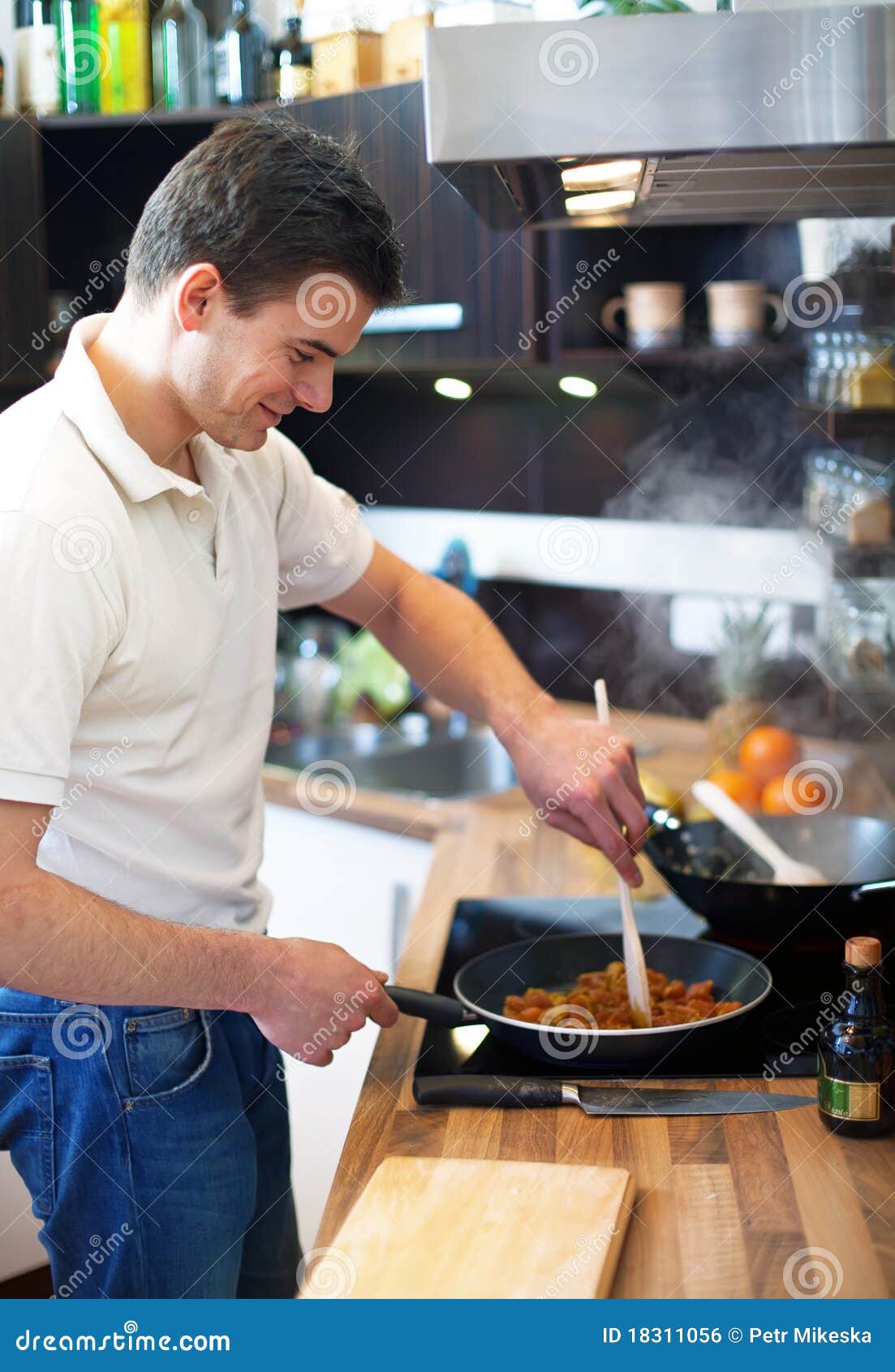Young man preparing lunch stock photo. Image of indoors - 18311056