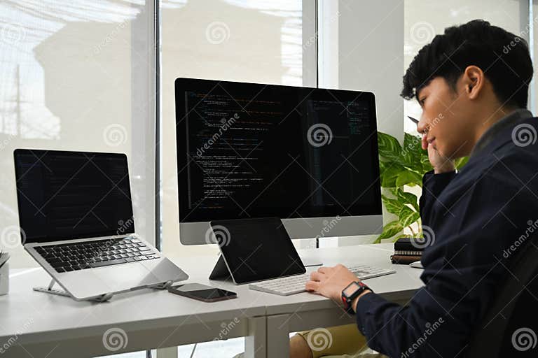 Young Man Programmer Working on Computer To Check Coding in Bugging System in it Office Stock ...