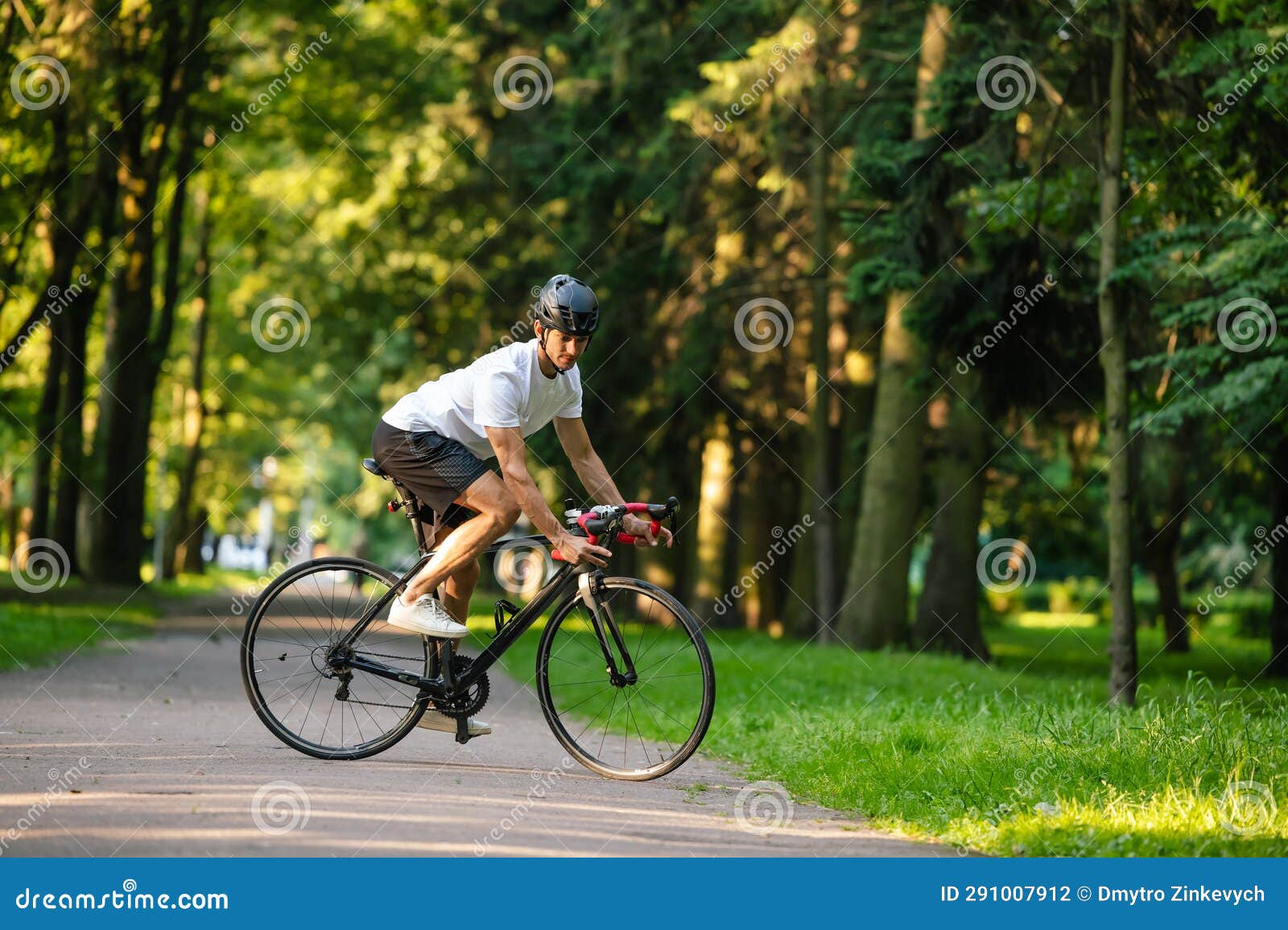 Young Man in Protective Hemlet on a Bike in the Park Stock Photo ...