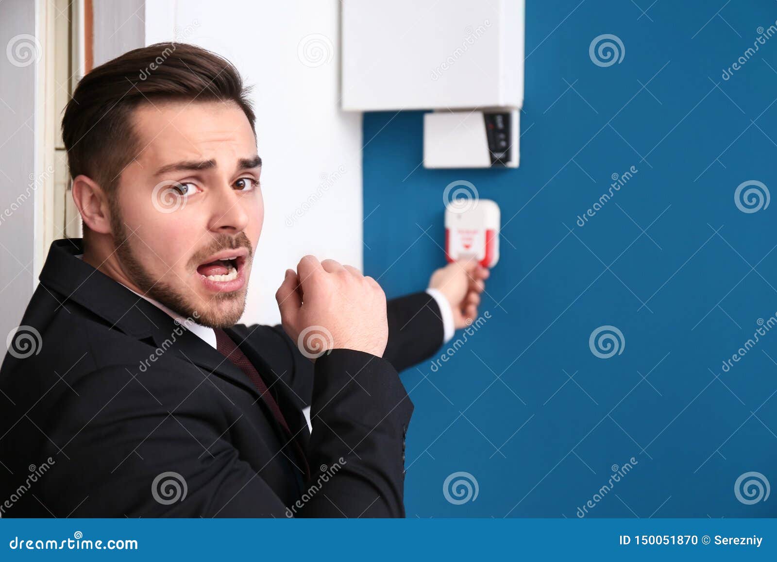 Young Man Pulling Handle of Fire Alarm Station, Indoors Stock Photo ...