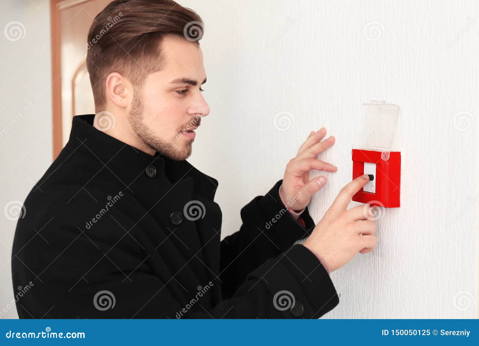 Young Man Pushing Button of Fire Alarm System, Indoors Stock Image ...