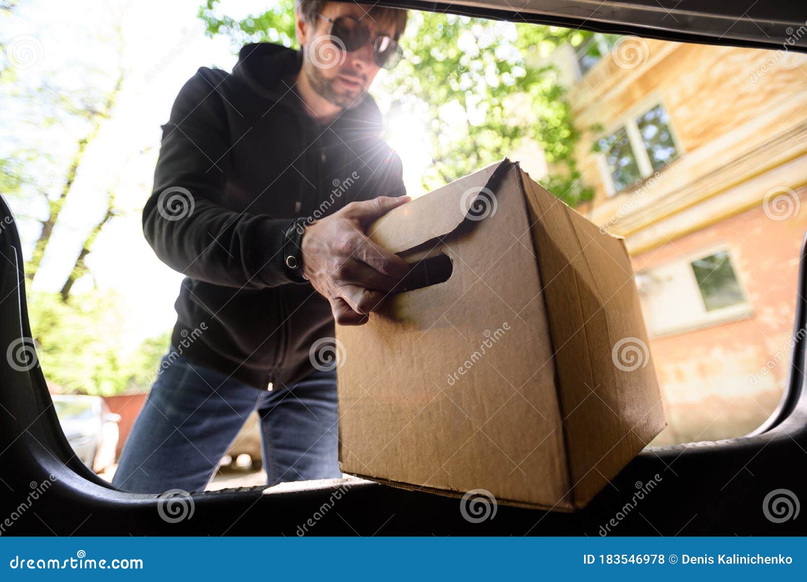 Young Man Puts a Box in the Trunk of a Car Inside View Stock Photo ...