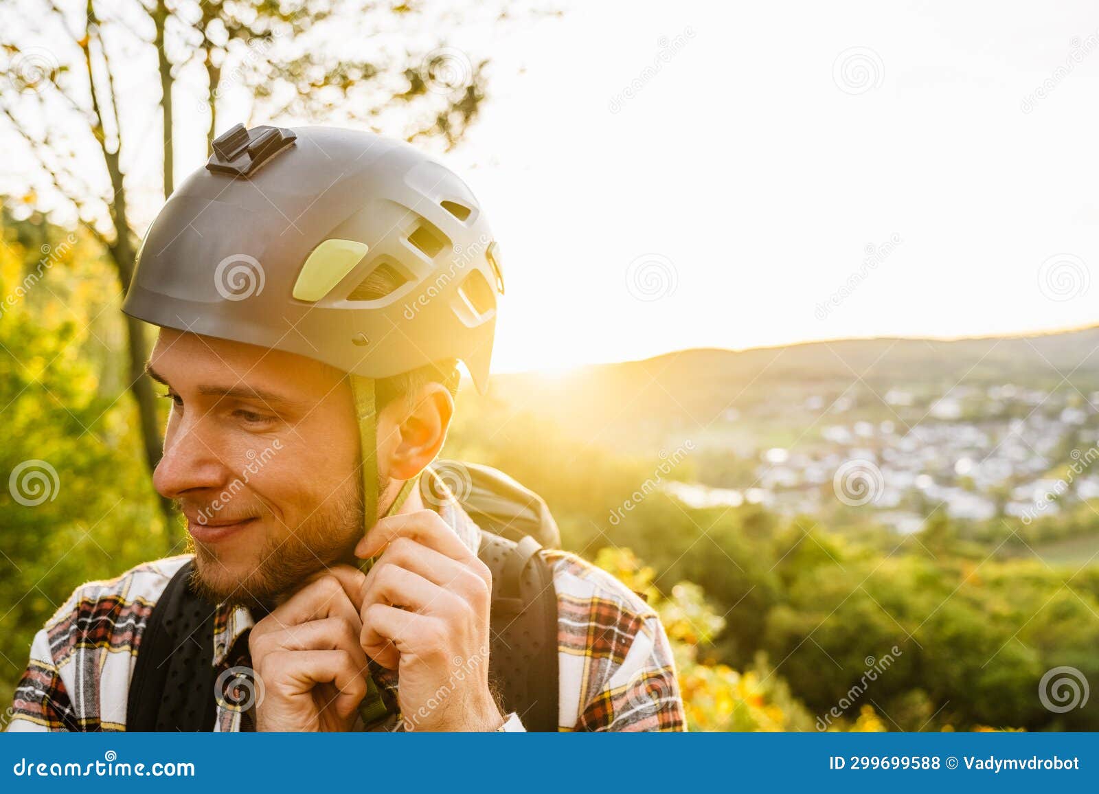 Young Man Putting on Helmet while Standing on Hillside Stock Photo ...