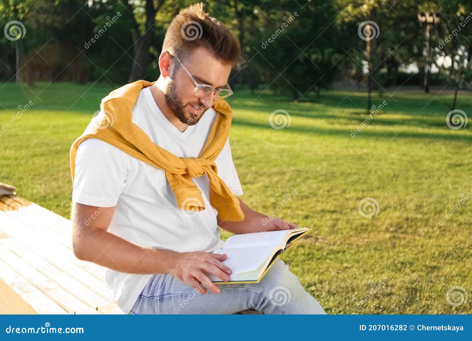 Young Man Reading Book on Bench in Park Stock Photo - Image of nature ...