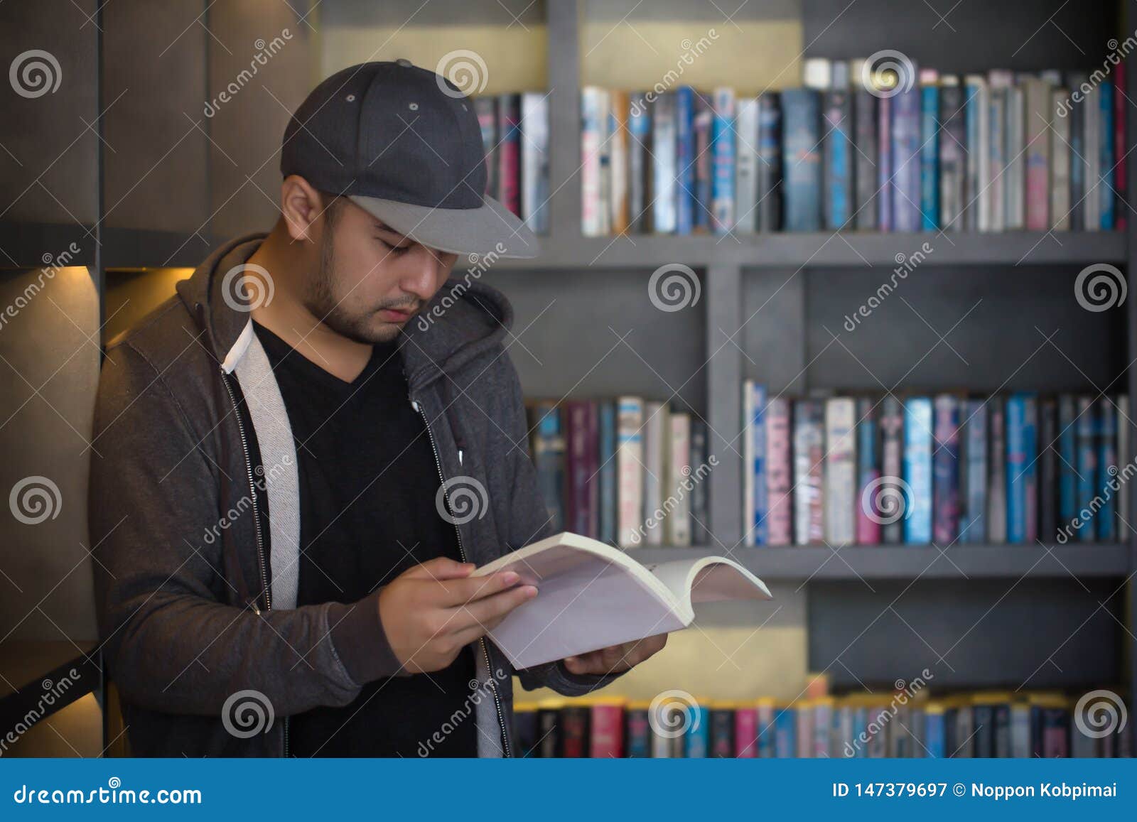 Young Man Reading Book in Library. Student in College Study from Book ...