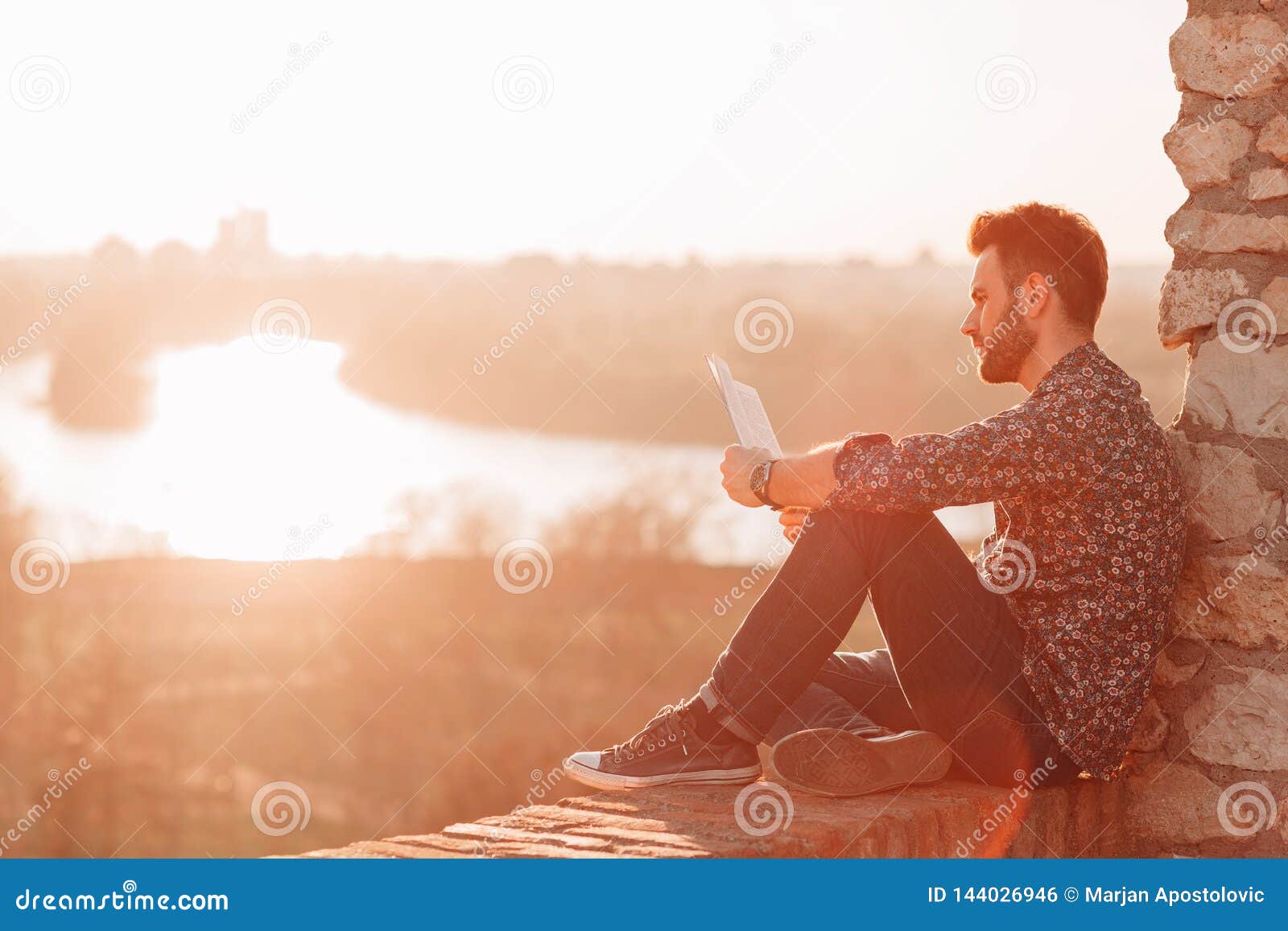 Young Man Reading a Book Outdoors Stock Photo - Image of casual ...