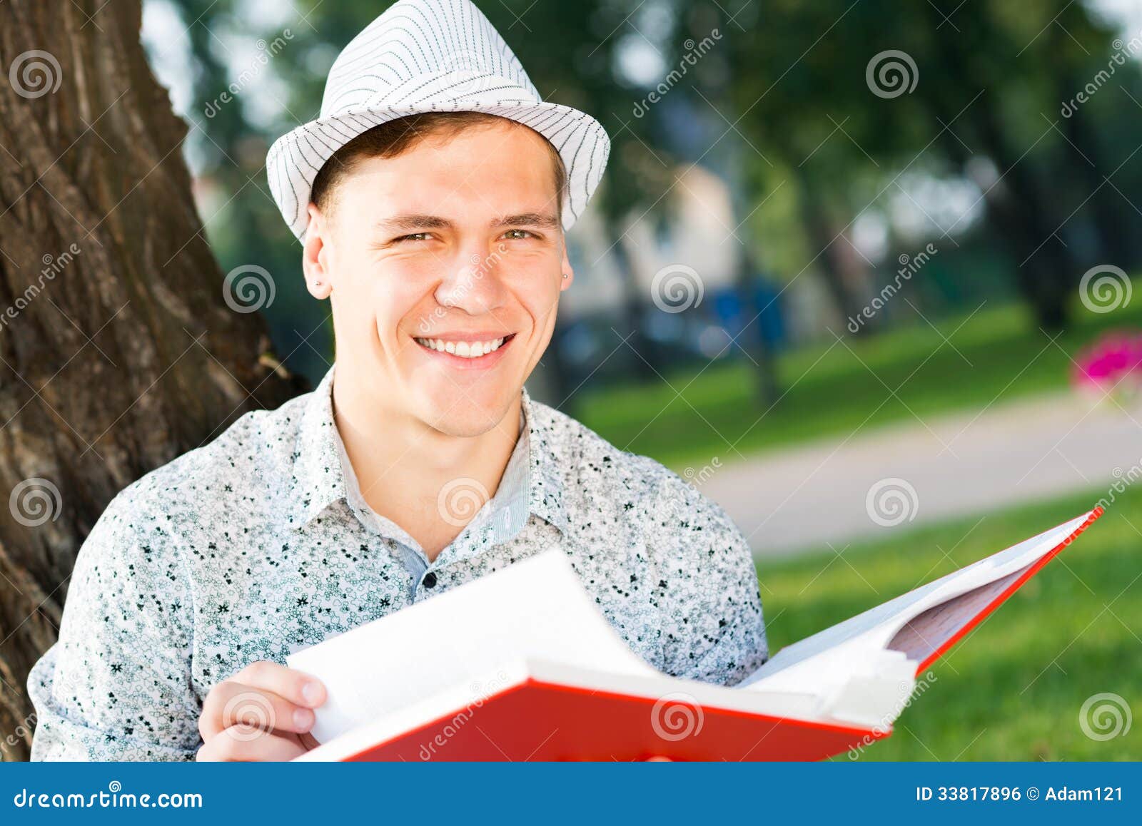 Young man reading a book stock photo. Image of grass - 33817896