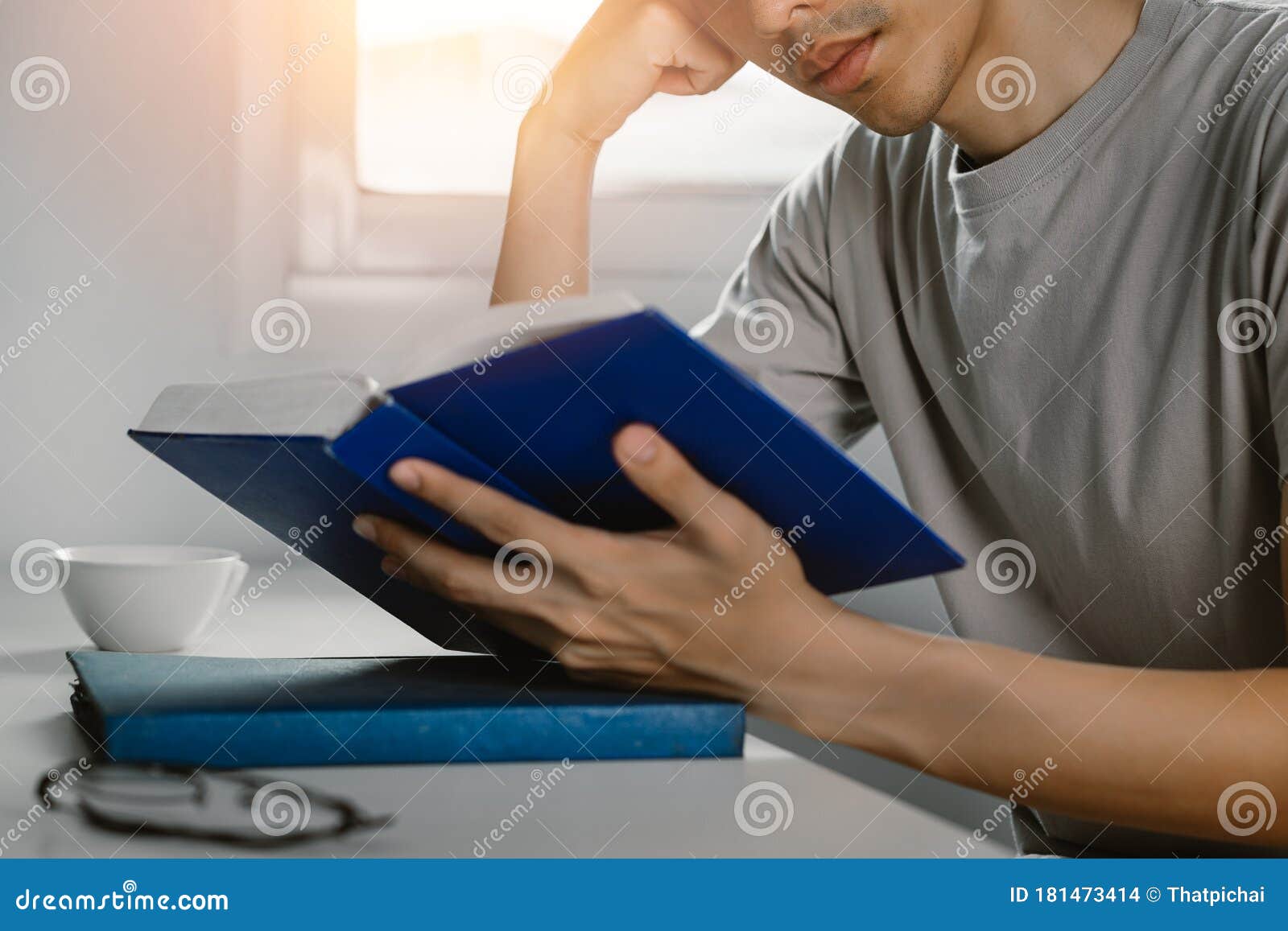Young Man Reading Book at Work Desk in Free Time from Working at Home ...