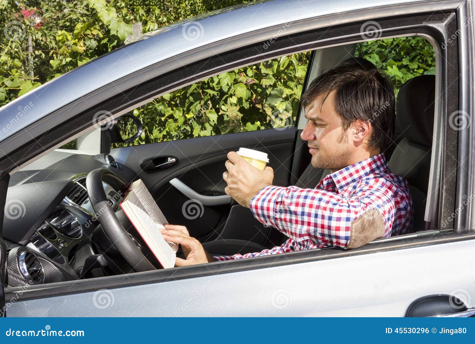 Young Man Reading and Drinking Coffee while Driving Stock Photo - Image ...