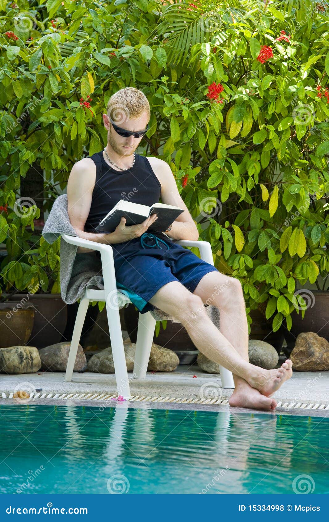 Young Man Reading Nearby the Swimming Pool Stock Photo - Image of ...