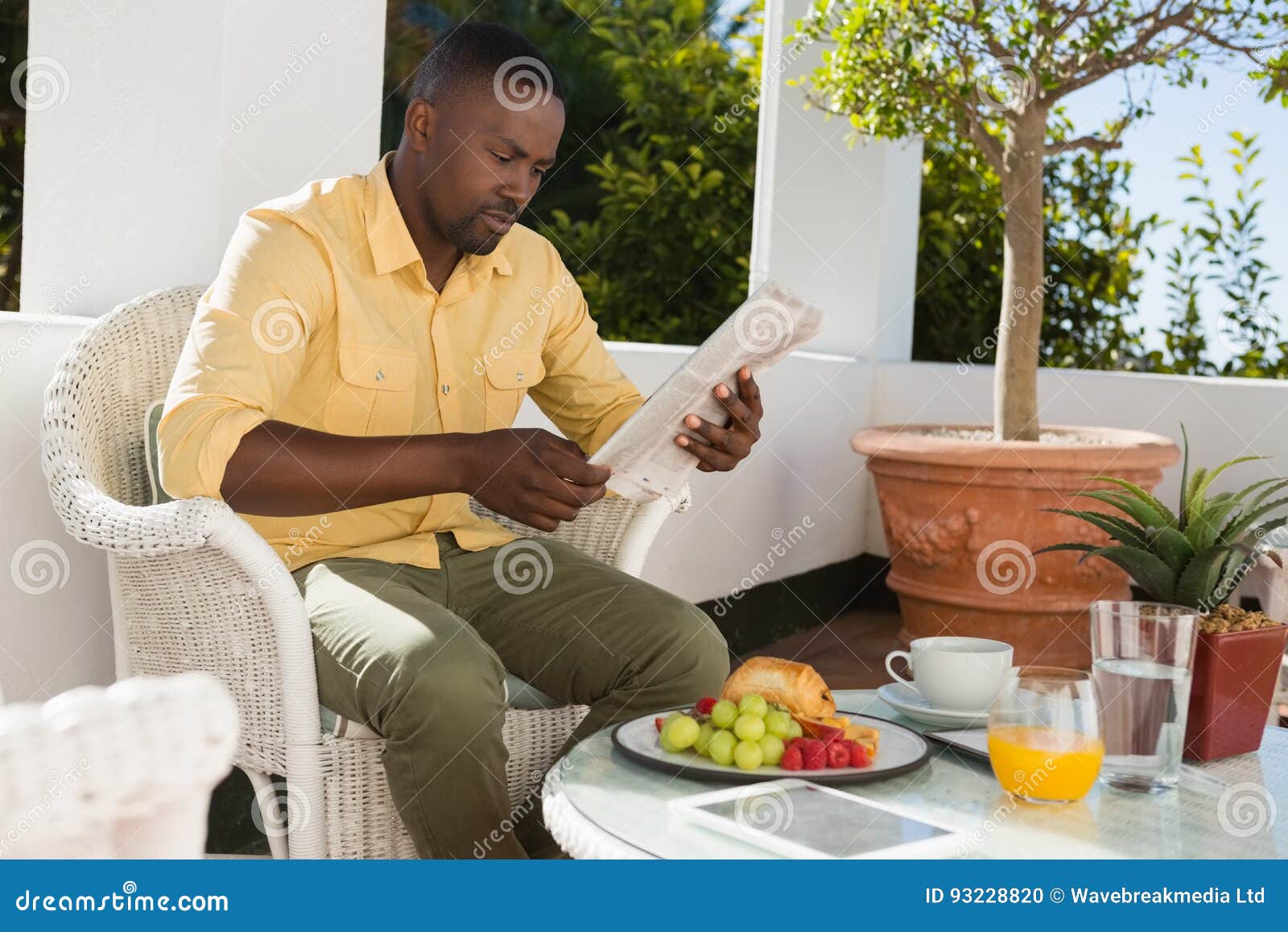 Young Man Reading Newspaper by Breakfast Table Stock Photo - Image of ...