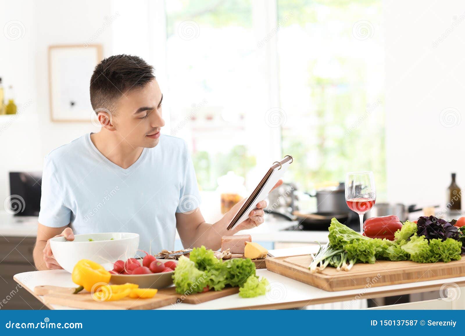Young Man Reading Recipe Book in Kitchen Stock Image - Image of ...