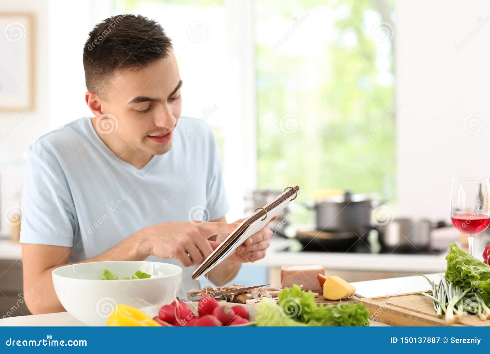 Young Man Reading Recipe Book in Kitchen Stock Image - Image of indoors ...