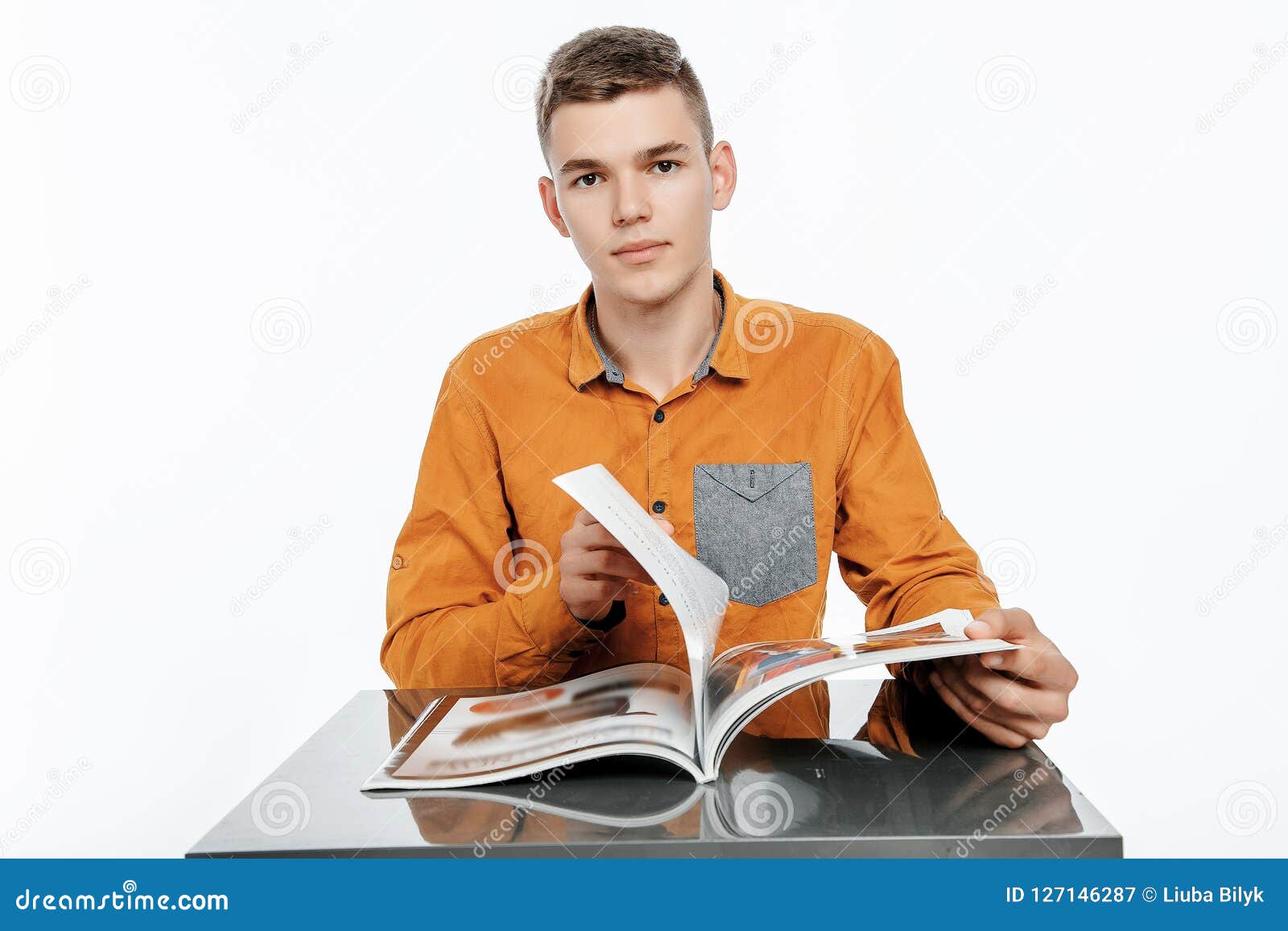 A Young Man Reads a Book. the Guy is Browsing the Magazine. Reading ...