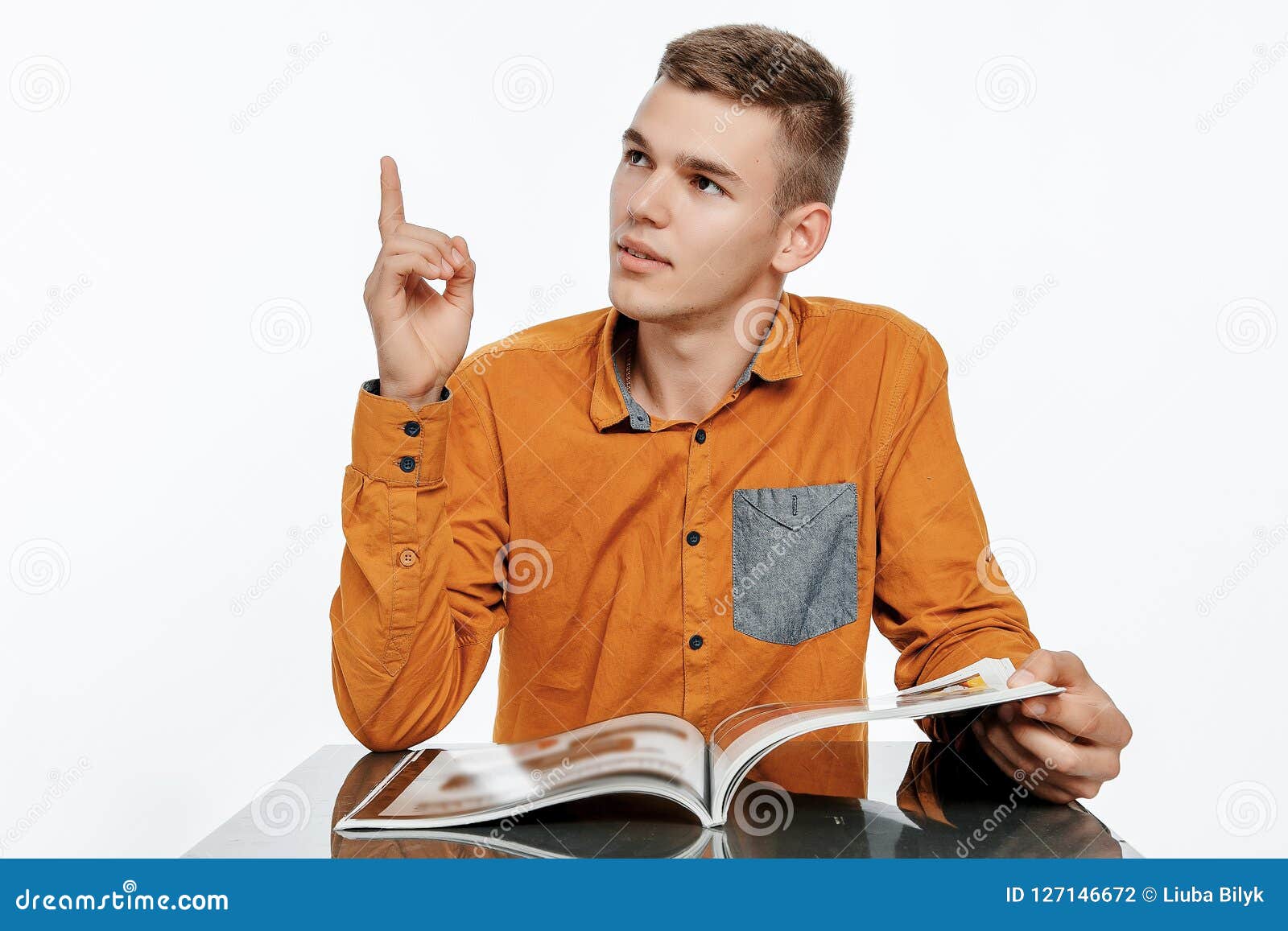 A Young Man Reads a Book. the Guy is Browsing the Magazine. Reading ...