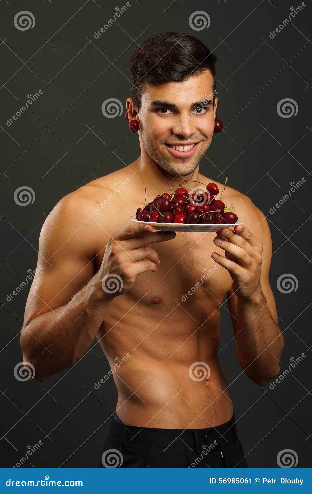 Young man with red cherry stock image. Image of gray - 56985061