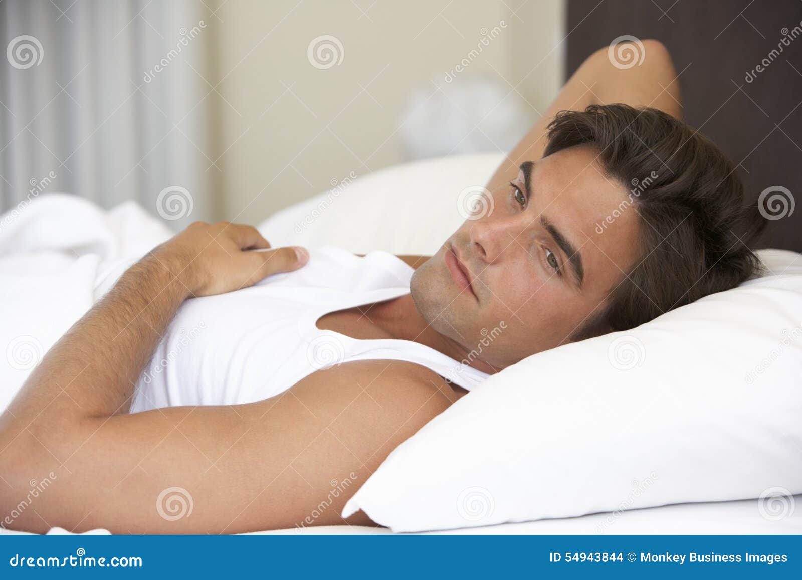 Young Man Relaxing on Bed stock photo. Image of inside - 54943844