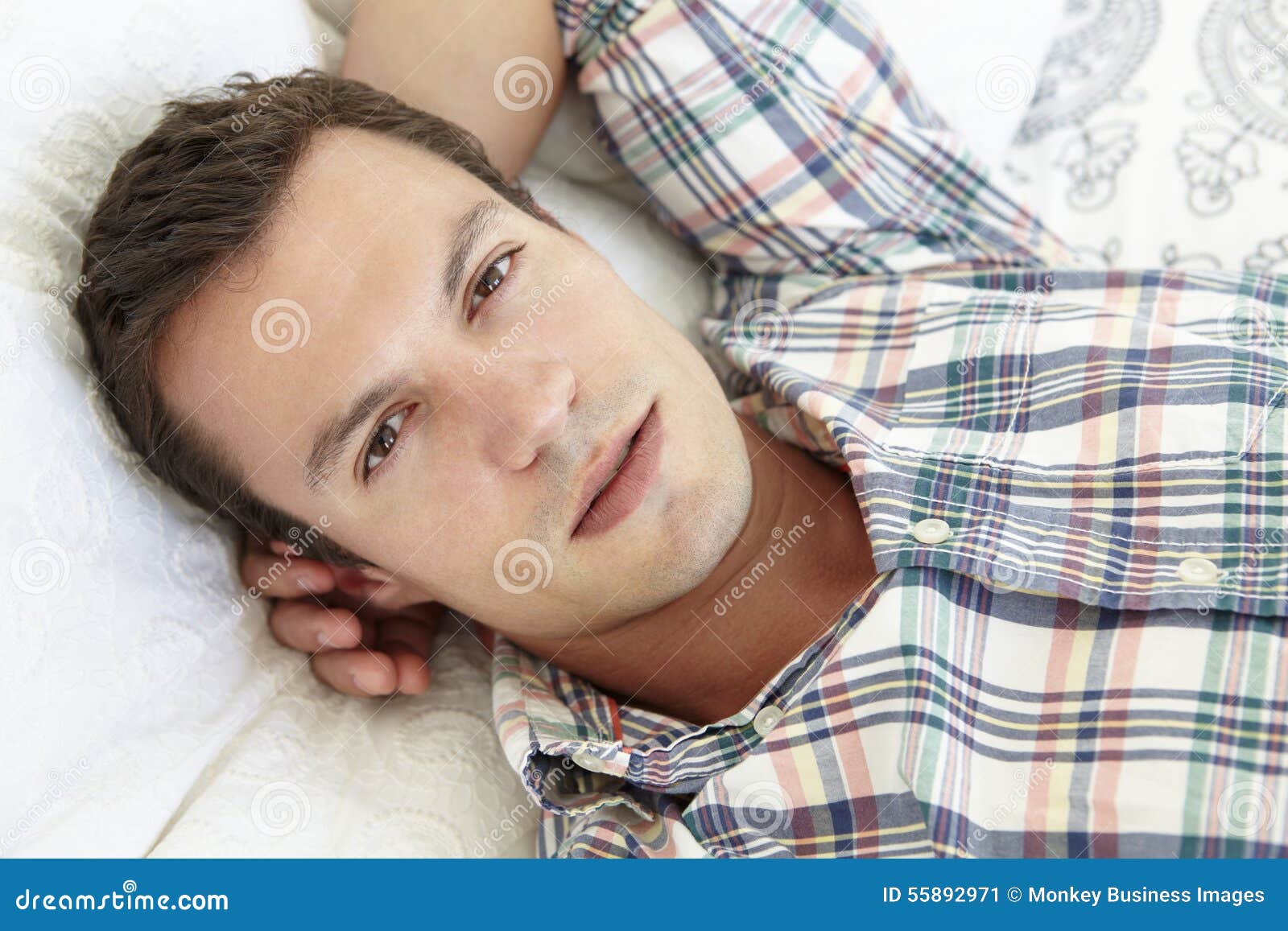 Young Man Relaxing on Bed stock image. Image of sleeping - 55892971