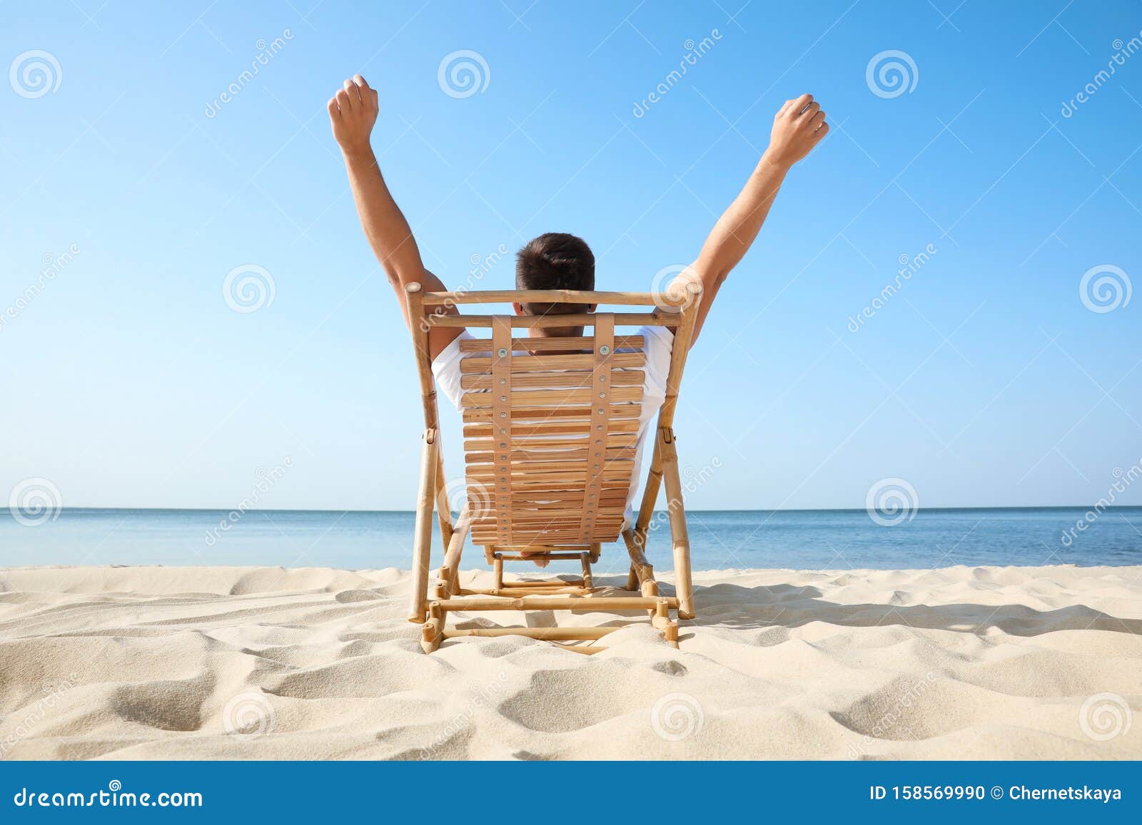 Young Man Relaxing in Deck Chair on Beach Stock Photo - Image of sandy ...
