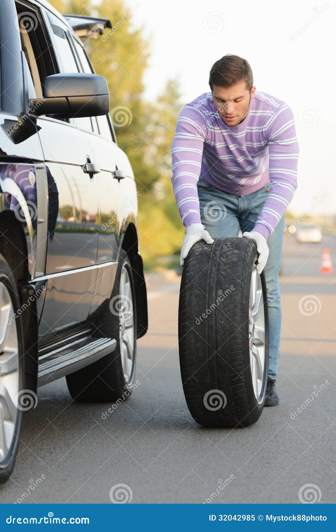 Young Man Rolling a Spare Wheel Stock Image - Image of stop, fixing ...