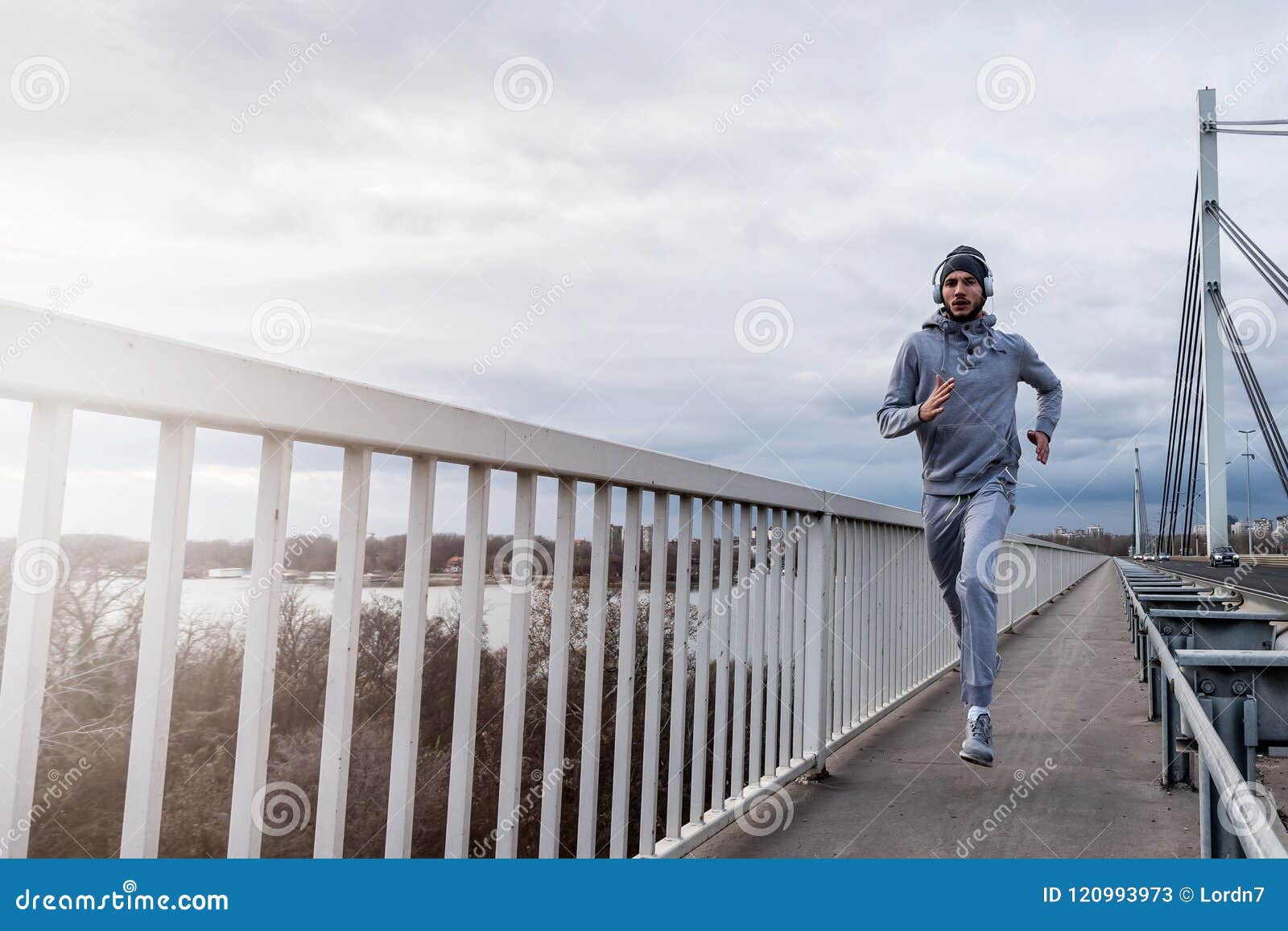 A Young Man Running on the Bridge Along a River. Stock Image - Image of ...