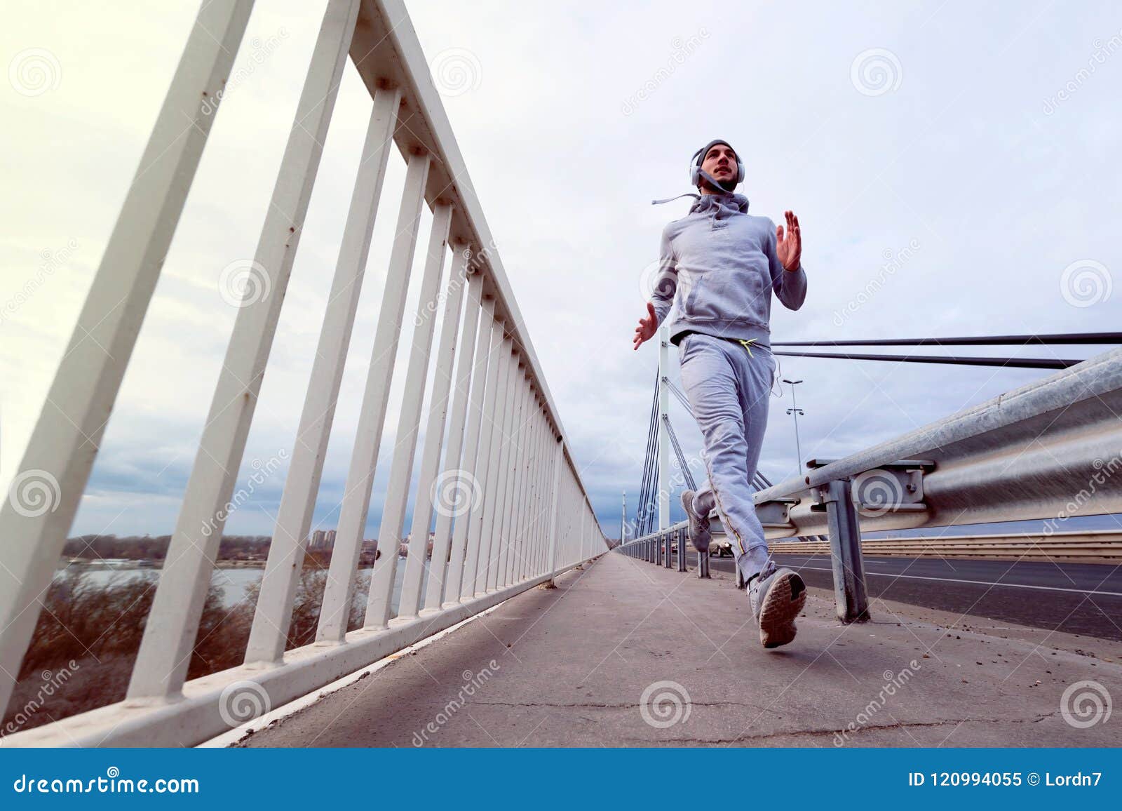 A Young Man Running on the Bridge Along a River. Stock Image - Image of ...