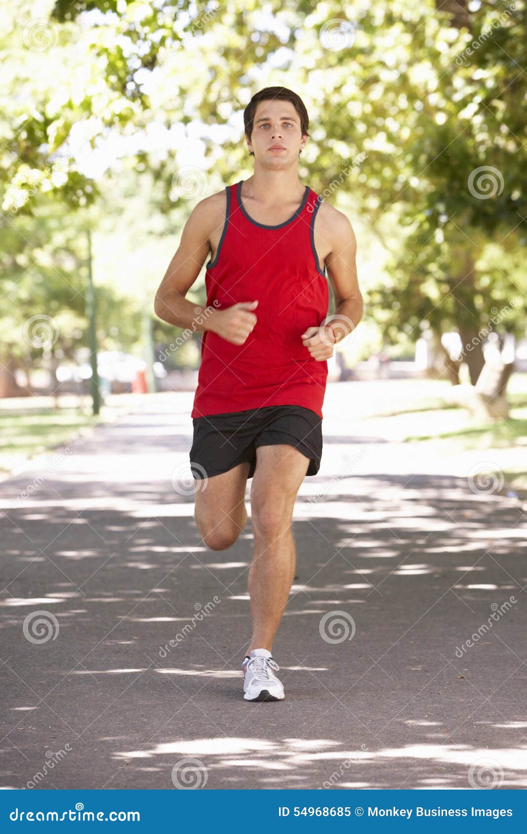 Young Man Running through Park Stock Image - Image of jogger, jogging ...
