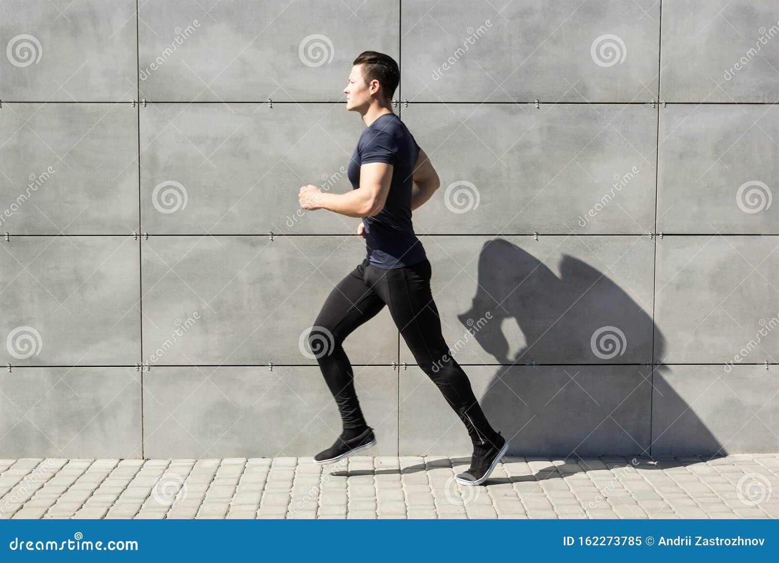 A Young Man Runs Against a Gray Wall, Urban Stock Image - Image of ...