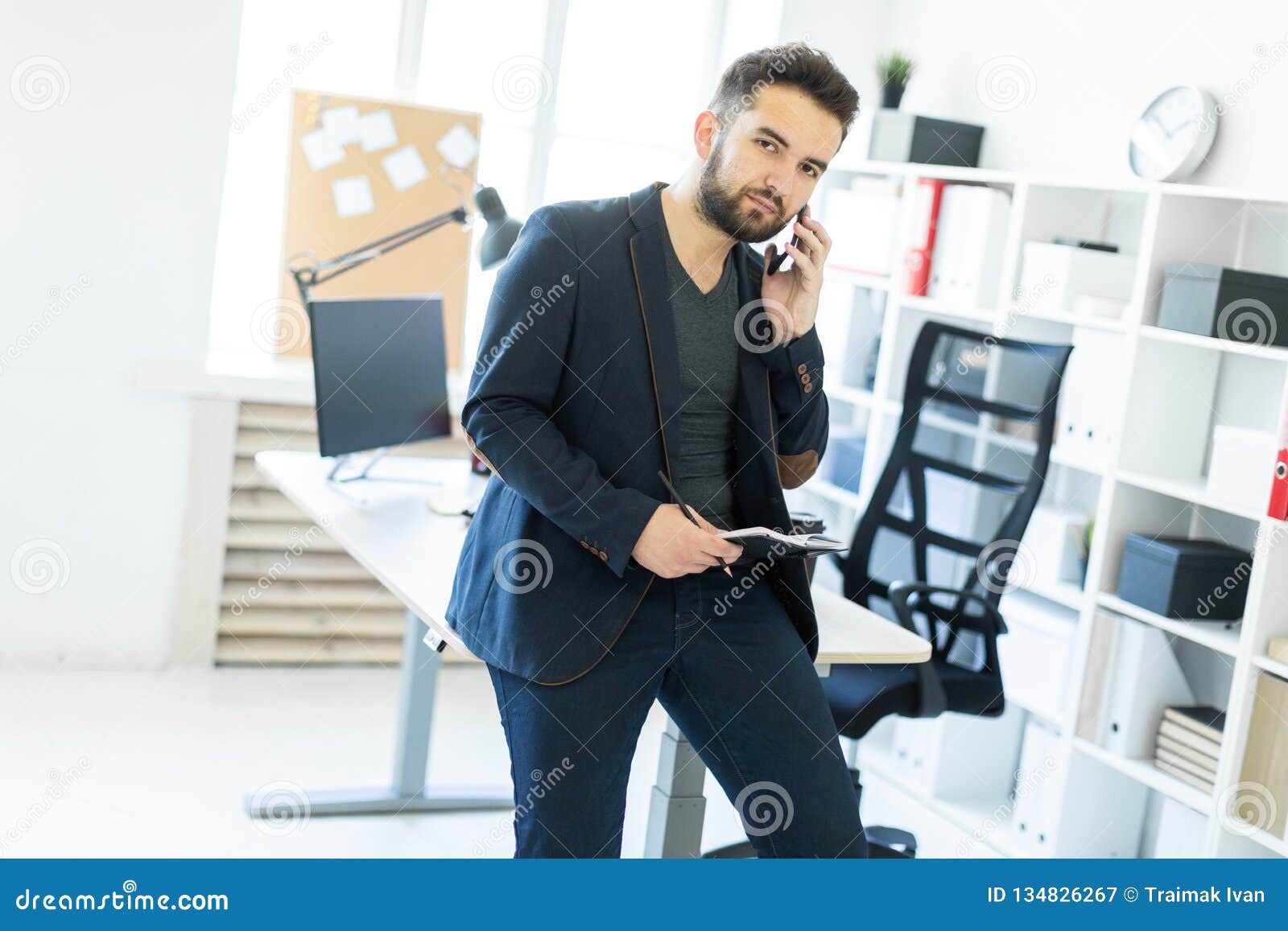 The Young Man Sat Down on a Table in the Office and Talking on the ...