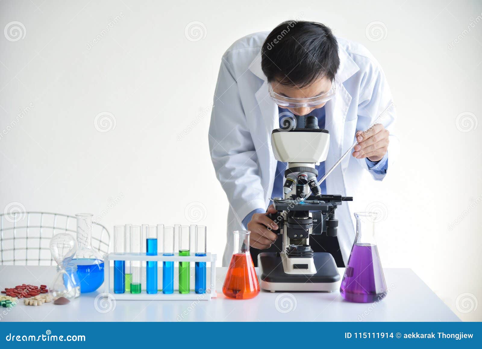 Young Man Scientist Looking through a Microscope. Stock Photo - Image ...