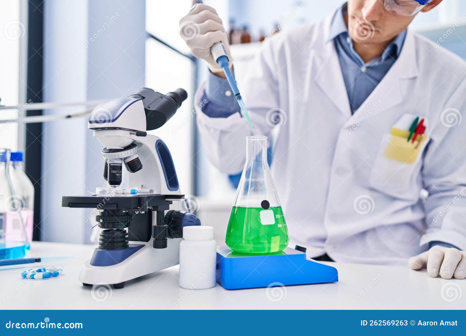 Young Man Scientist Pouring Liquid on Test Tube at Laboratory Stock ... Young Man Scientist Pouring Liquid on Test Tube at Laboratory Stock ...