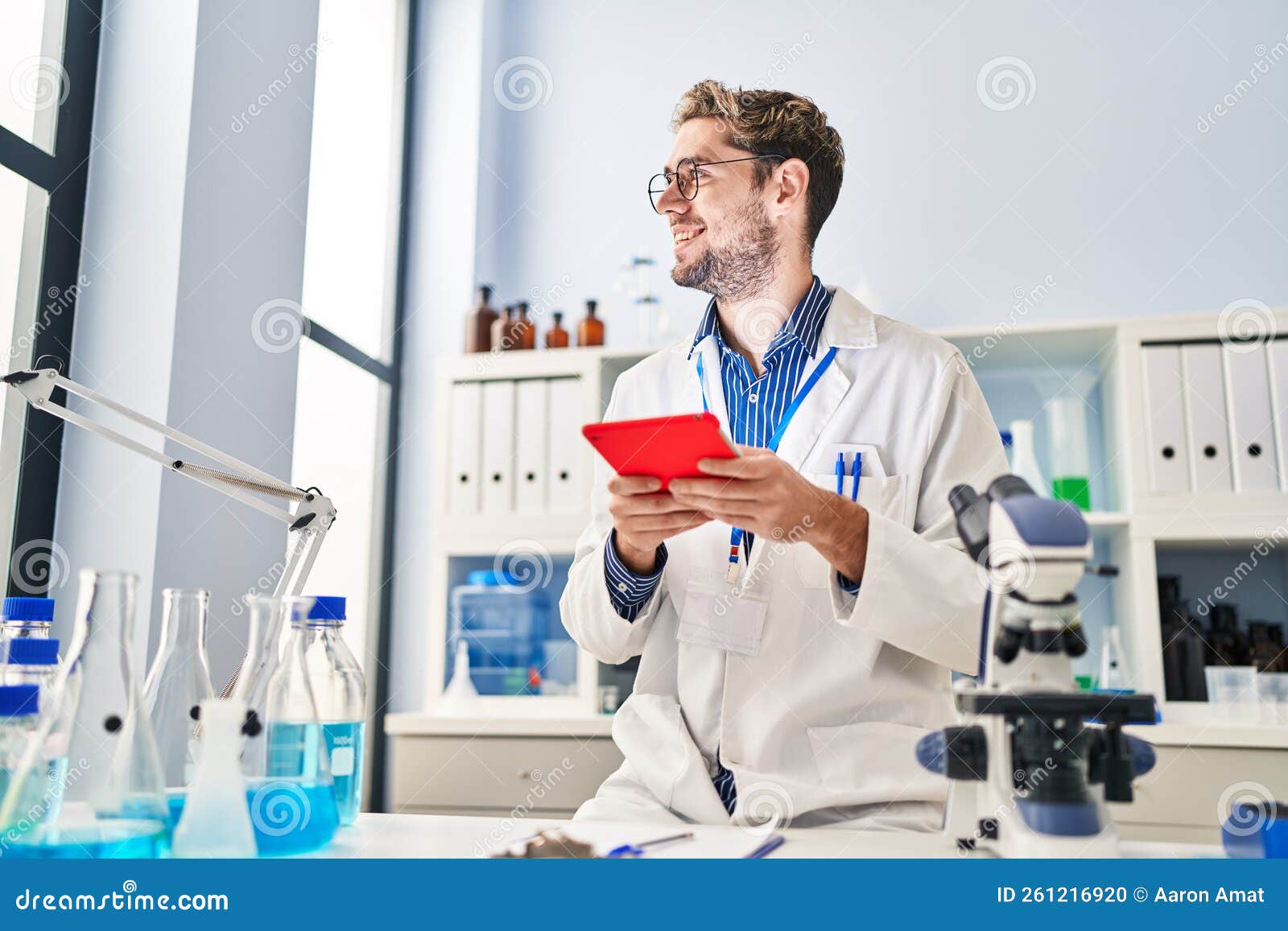 Young Man Scientist Smiling Confident Using Touchpad at Laboratory ...