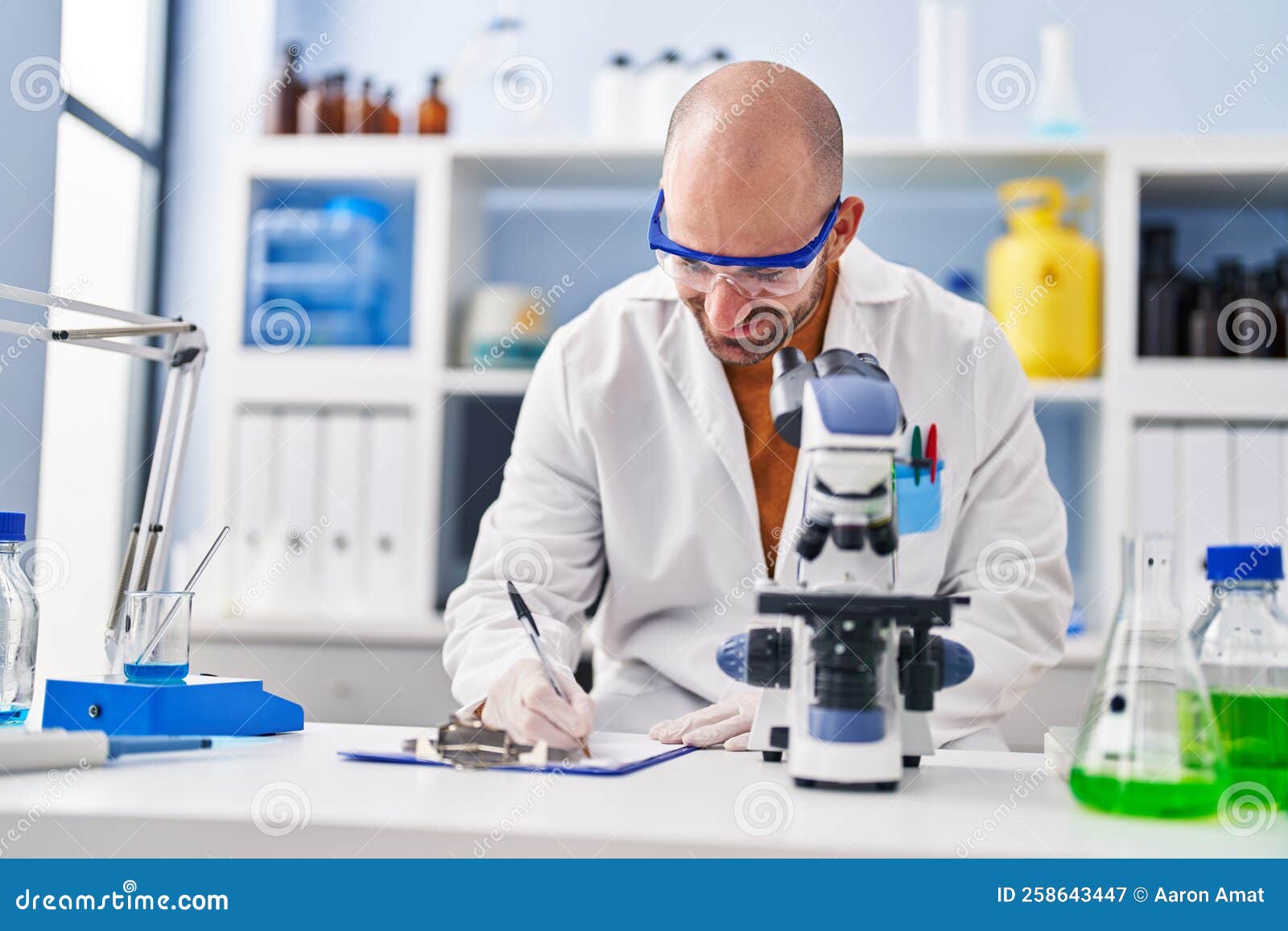 Young Man Scientist Writing on Clipboard at Laboratory Stock Image ...