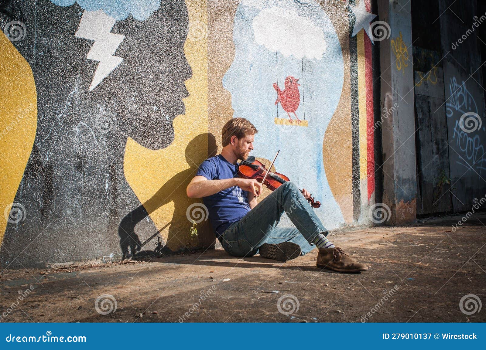 Young Man Seated Against a Graffiti Wall, Playing a Violin Editorial ...