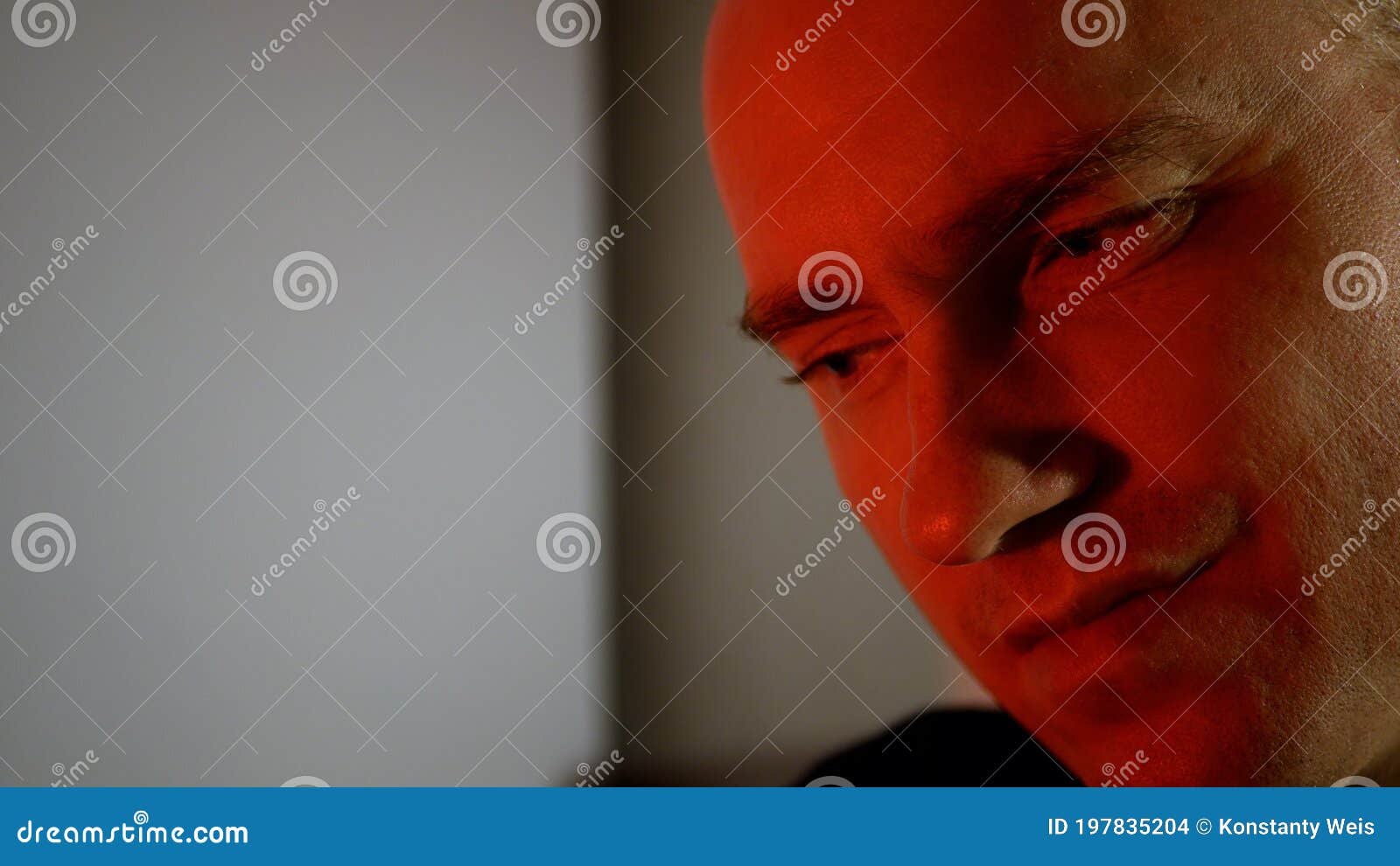 A Young Man with a Serious Look. Frowning Man in Red Tones Evil Smile ...