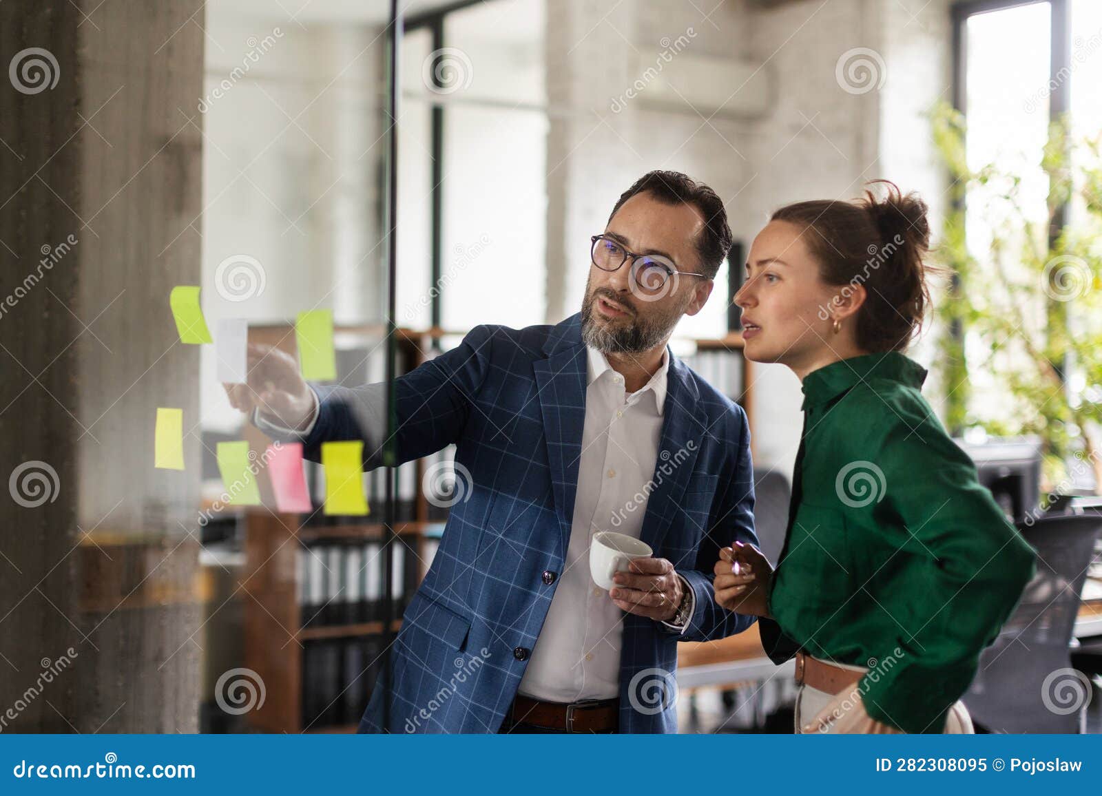 Young Man Showing Notes in Office To His Colleague. Stock Image - Image ...