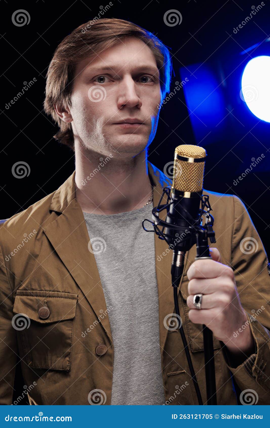 A Young Man is Singing with a Microphone in His Hands in the Stage ...
