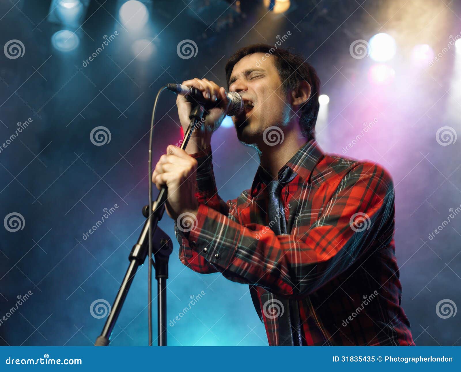 Young Man Singing into Microphone Stock Image - Image of artist, light ...