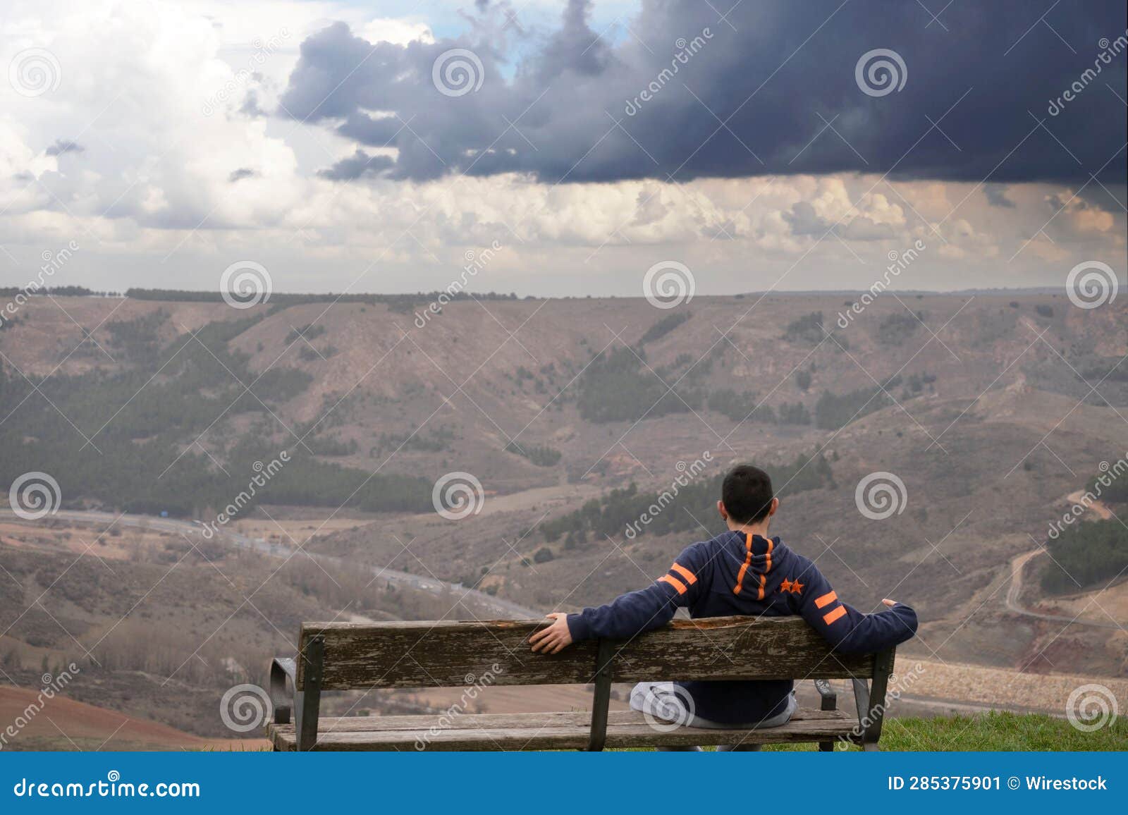 Young Man Sitting Alone on a Bench Overlooking the Mountain and Valley ...