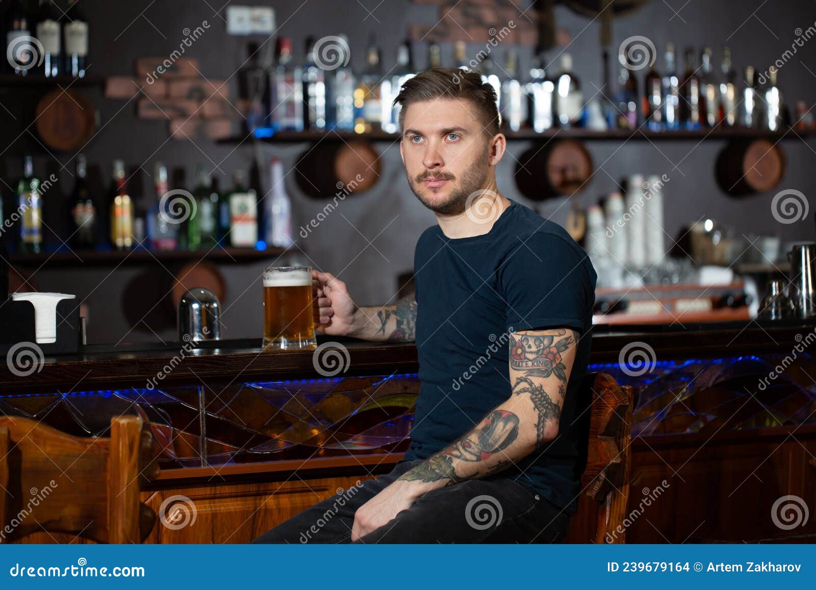 Young Man Sitting at Bar Counter with a Pint of Light Beer. Stock Photo ... Young Man Sitting at Bar Counter with a Pint of Light Beer. Stock Photo ...