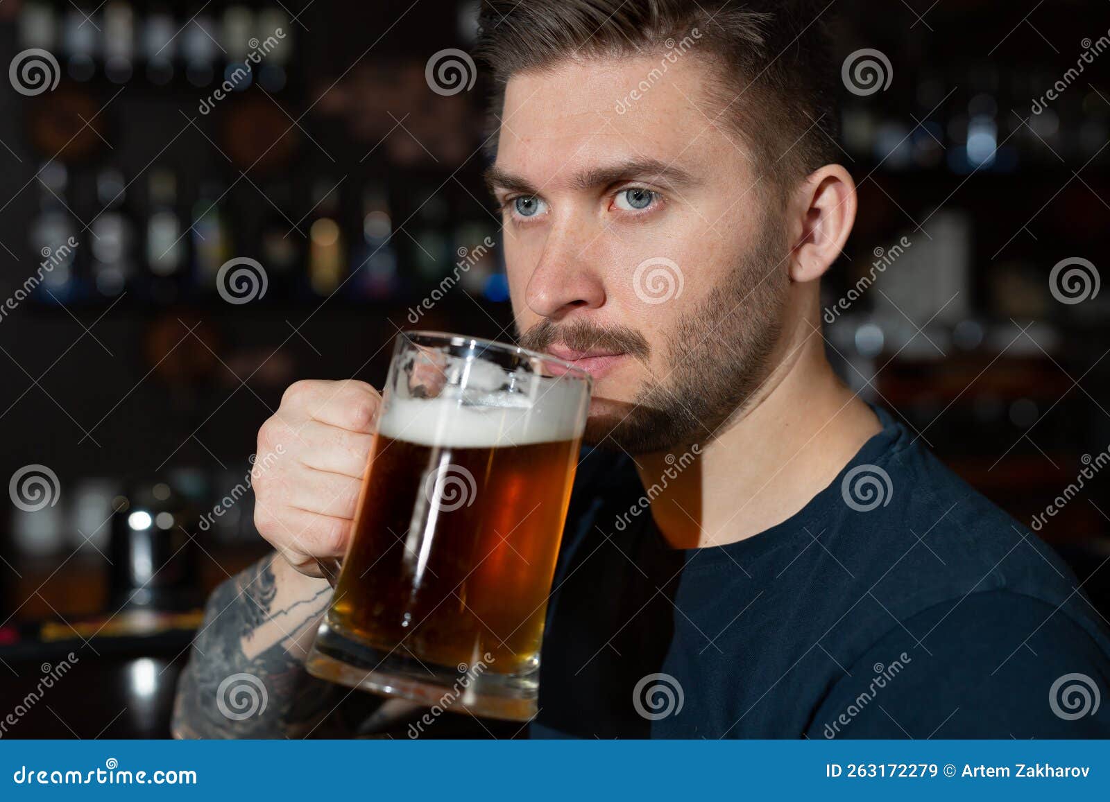 Young Man Sitting at Bar Counter with a Pint of Light Beer. Stock Image ... Young Man Sitting at Bar Counter with a Pint of Light Beer. Stock Image ...