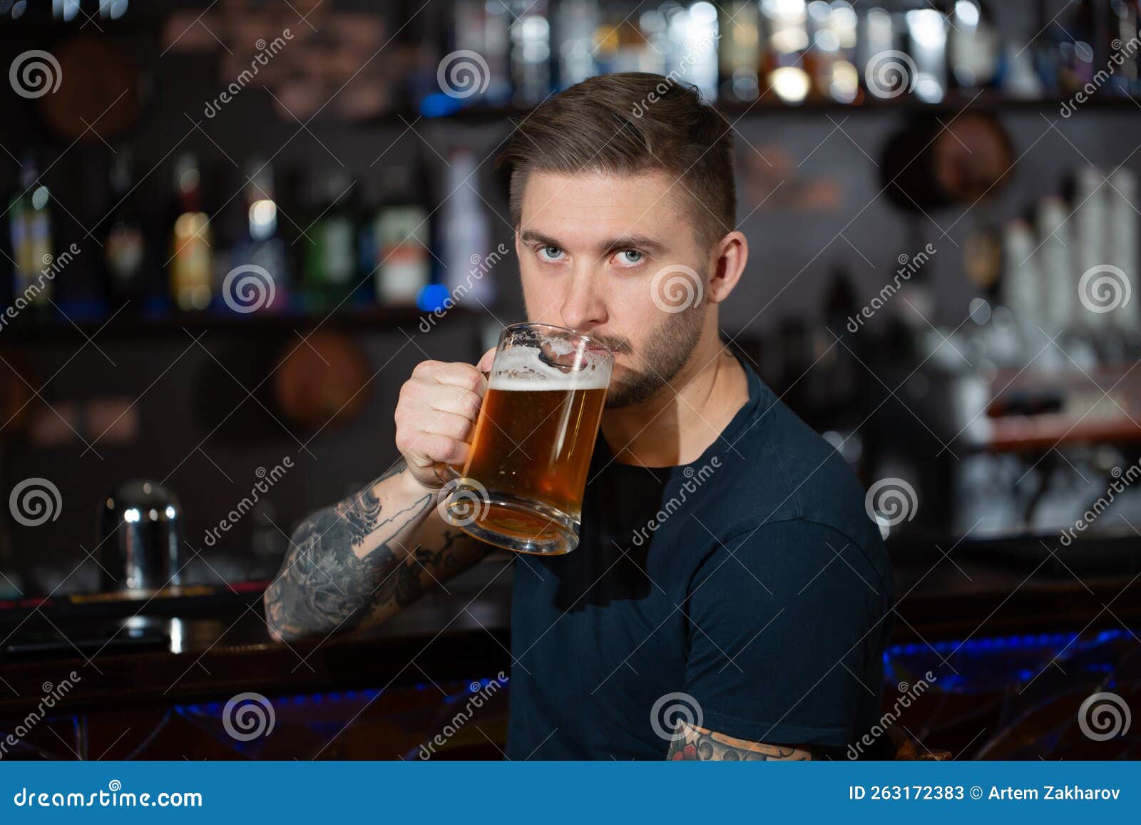 Young Man Sitting at Bar Counter with a Pint of Light Beer. Stock Image ... Young Man Sitting at Bar Counter with a Pint of Light Beer. Stock Image ...