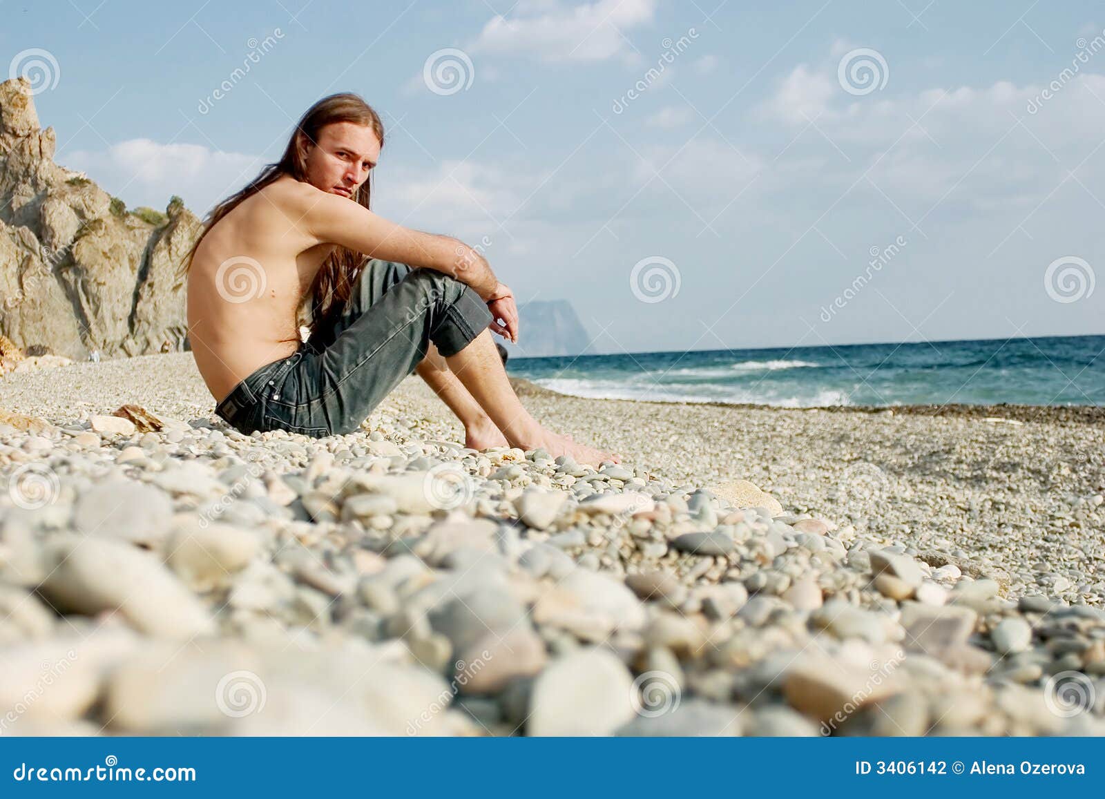 Young Man Sitting on the Beach Stock Photo - Image of solitude, stones ...