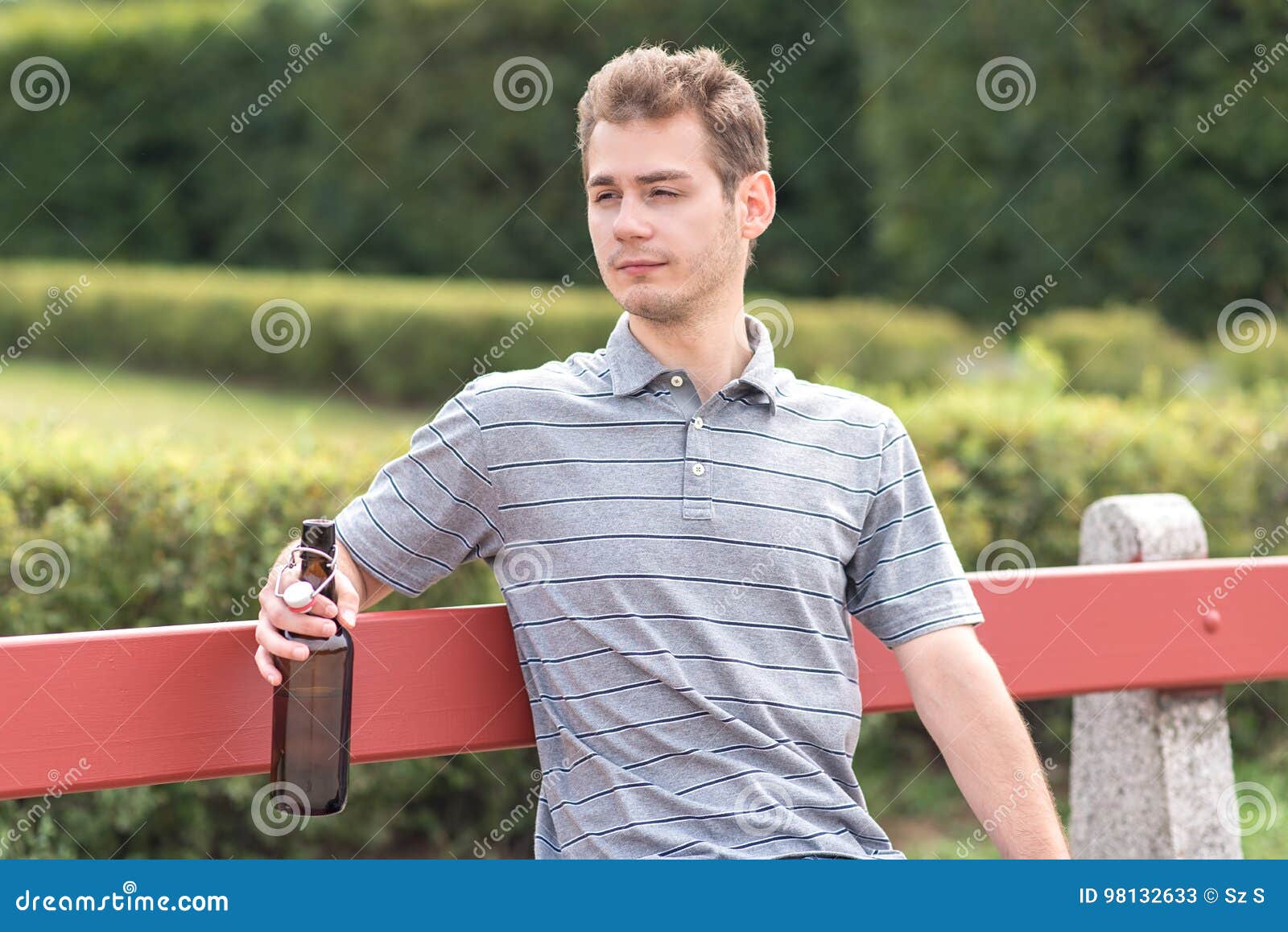 Young Man Sitting on Bench with a Bottle of Beer Stock Image - Image of ...