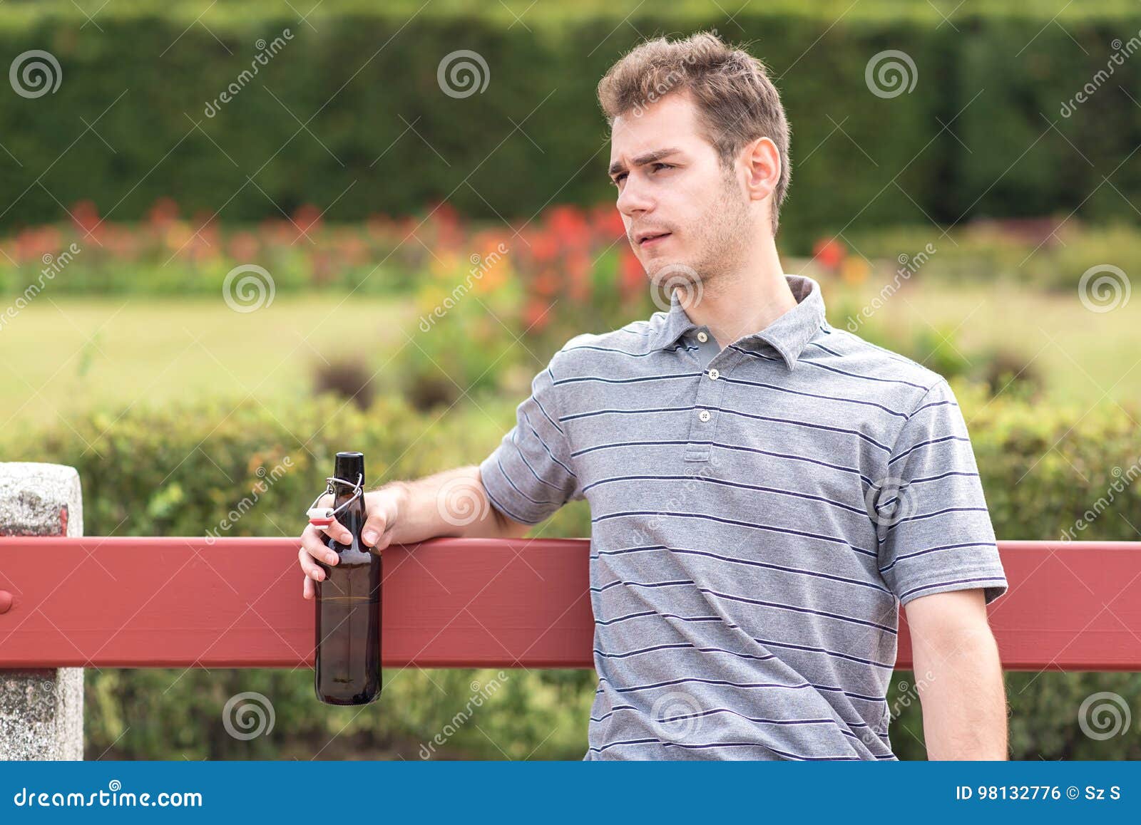 Young Man Sitting on Bench with a Bottle of Beer Stock Photo - Image of ...