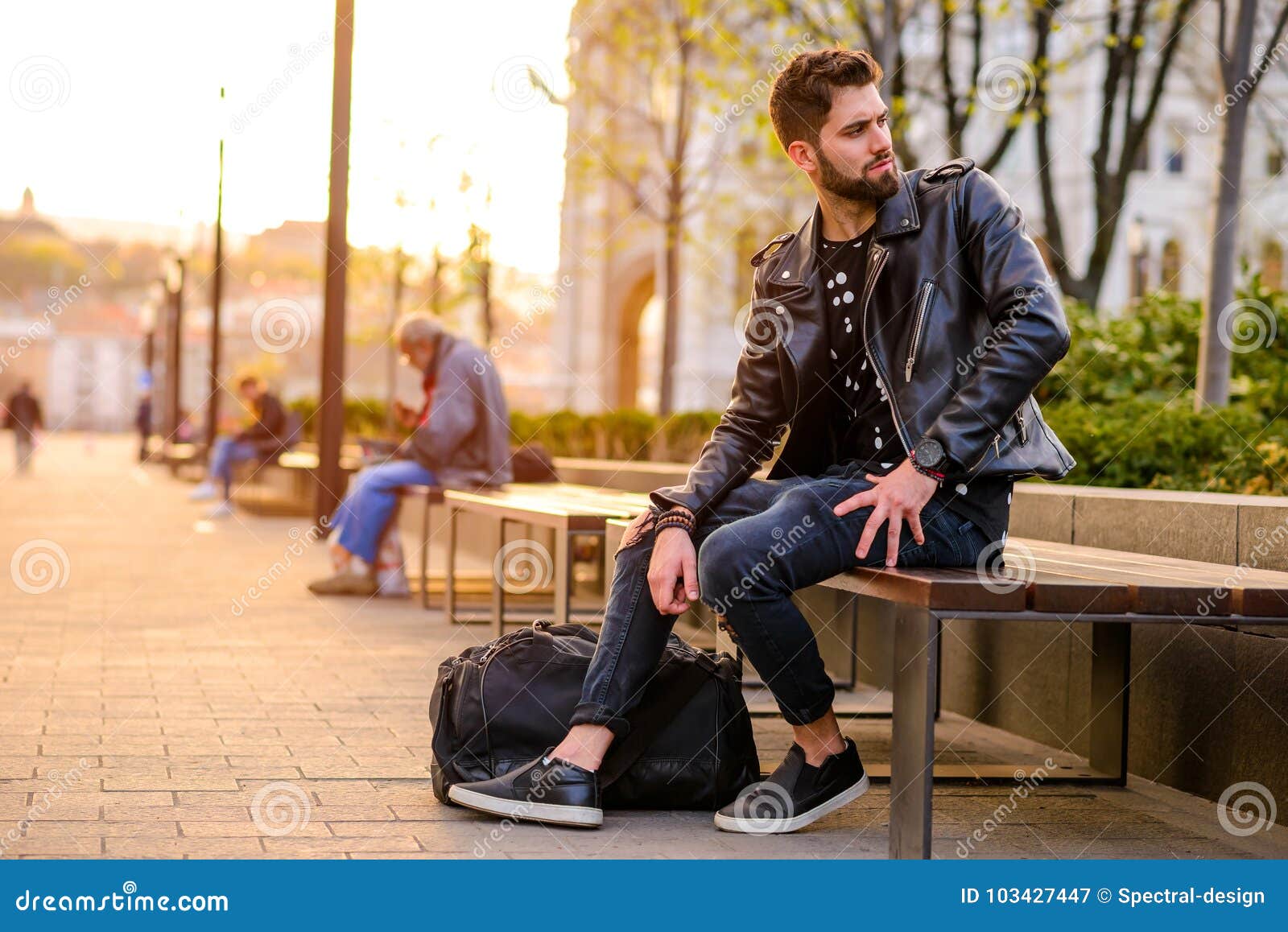 Young Man Sitting on a Bench Stock Image - Image of black, look: 103427447