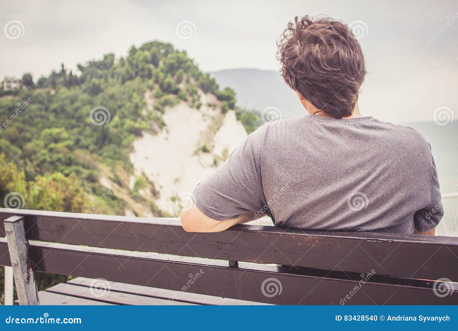 Young Man Sitting on Bench Overlooking Sea Stock Photo - Image of ...