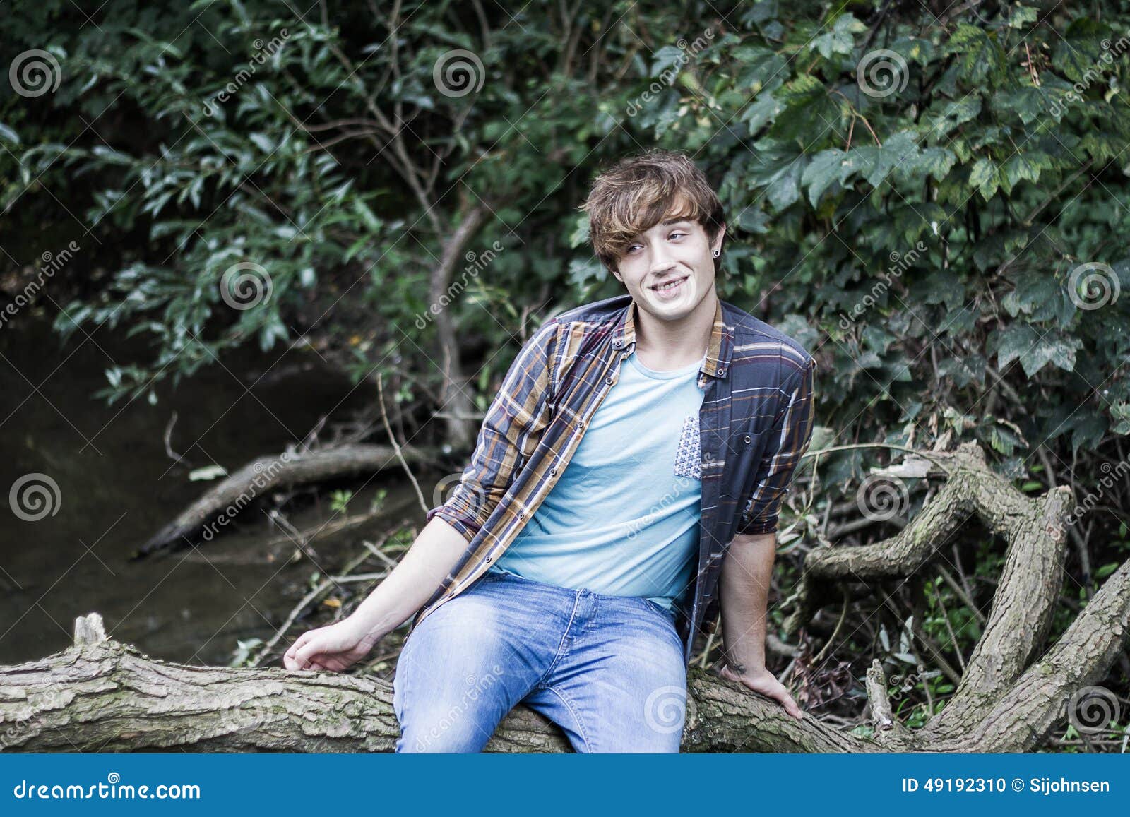 Young Man Sitting on Branch Over a Stream Stock Photo - Image of nature ...