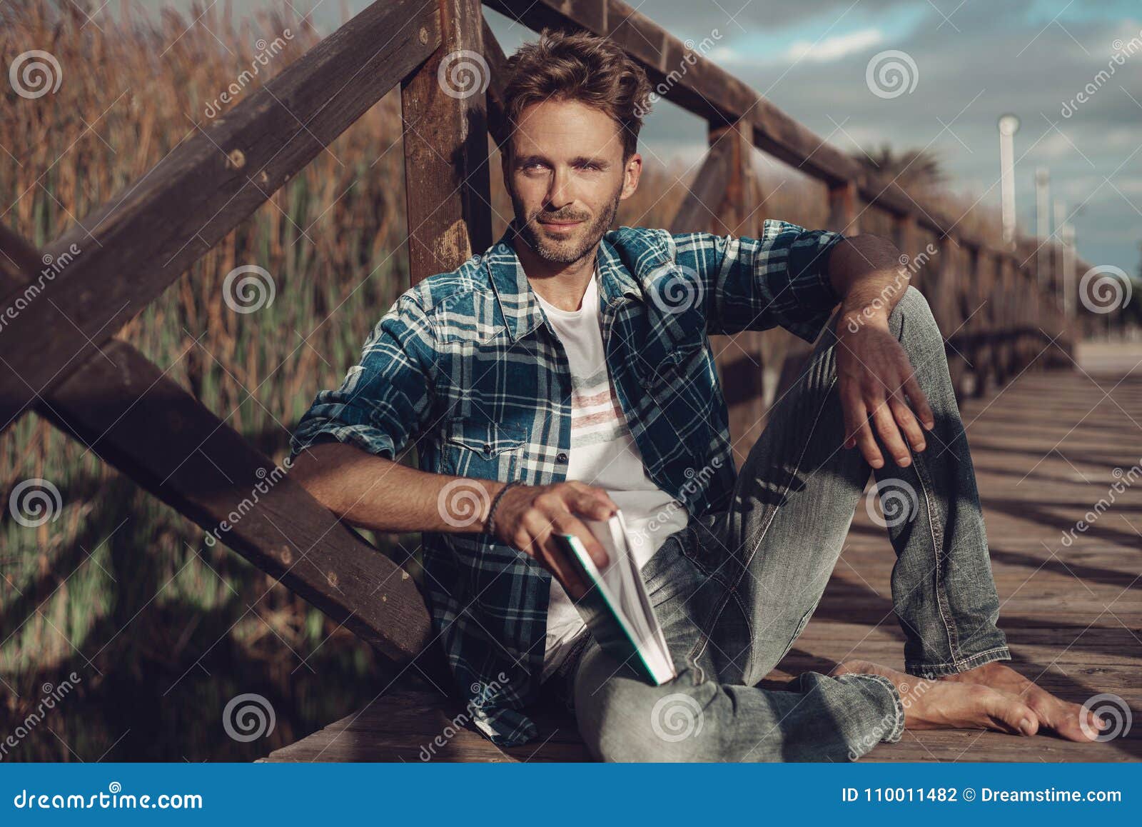 Young Man Sitting on a Bridge Stock Photo - Image of happy, learning ...