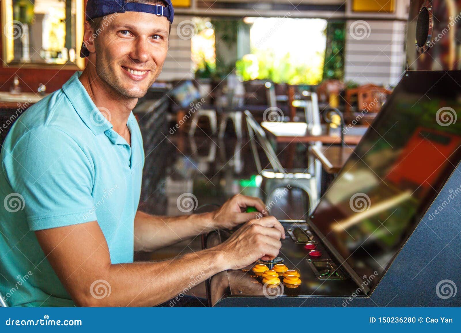 Young Man Sitting in Casino and Playing Amusement Machine. Stock Photo ...